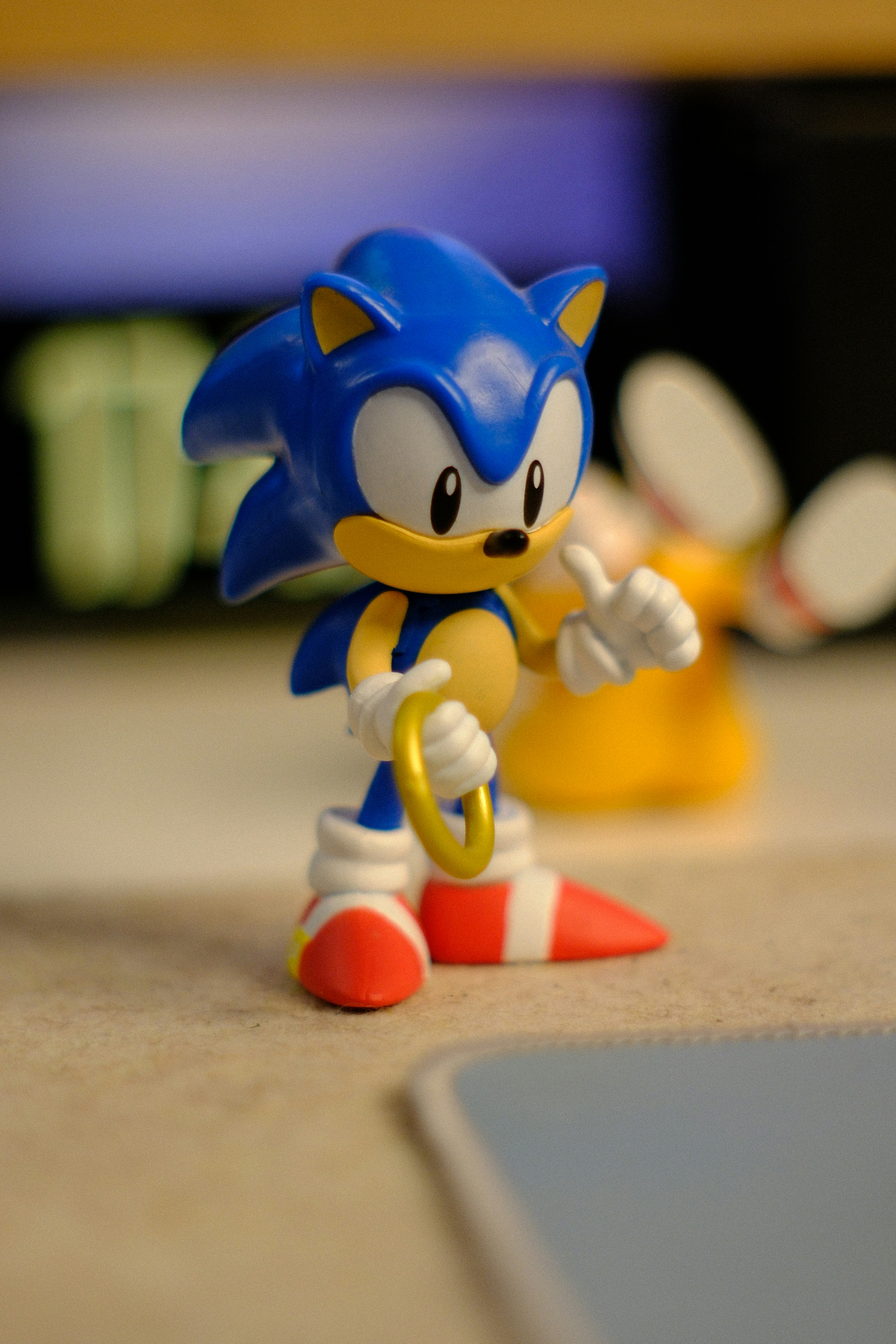 A sonic the hedgehog action figure holds a golden ring.