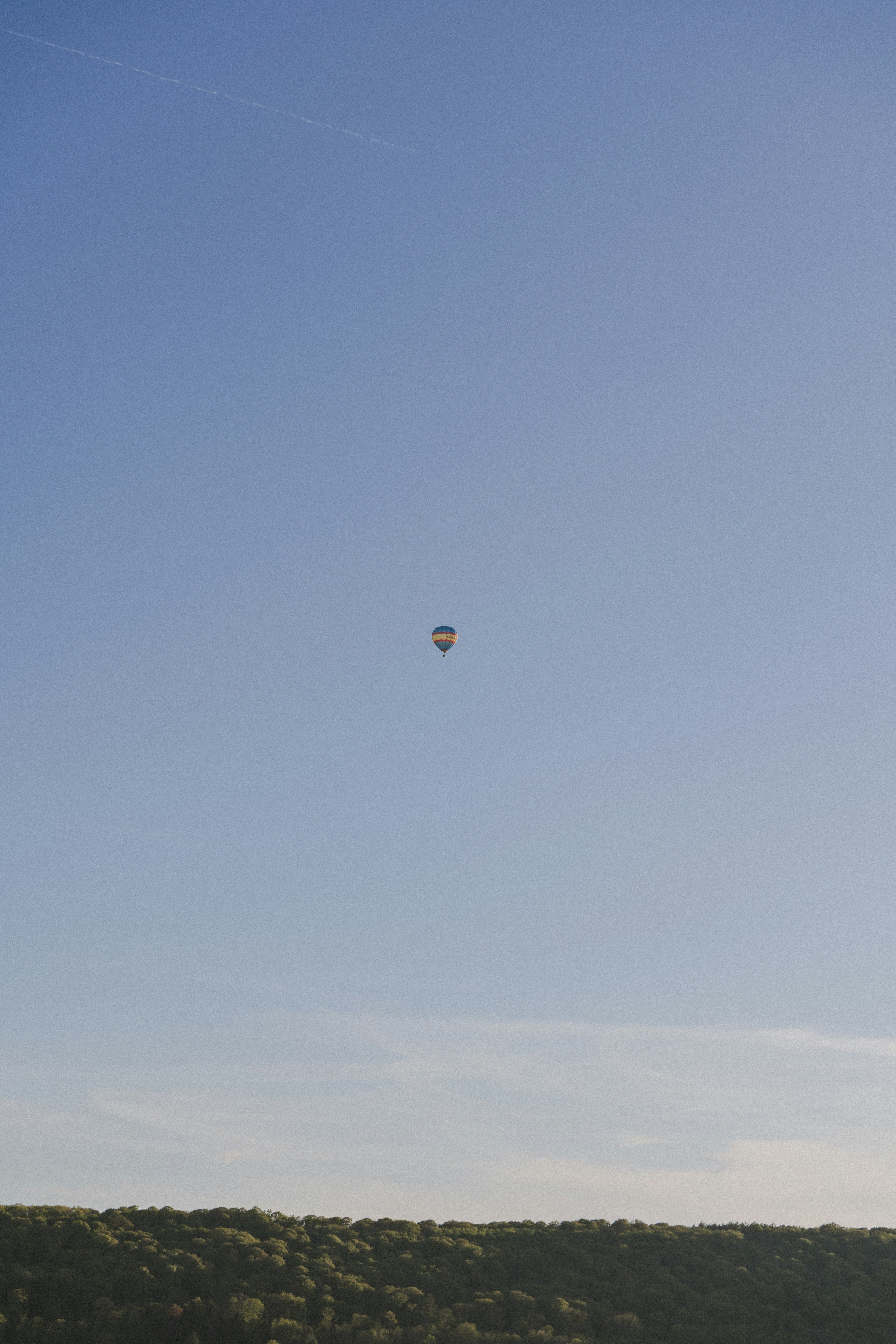 A Lone Balloon Drifts Across a Clear Sky Above a Quiet Horizon