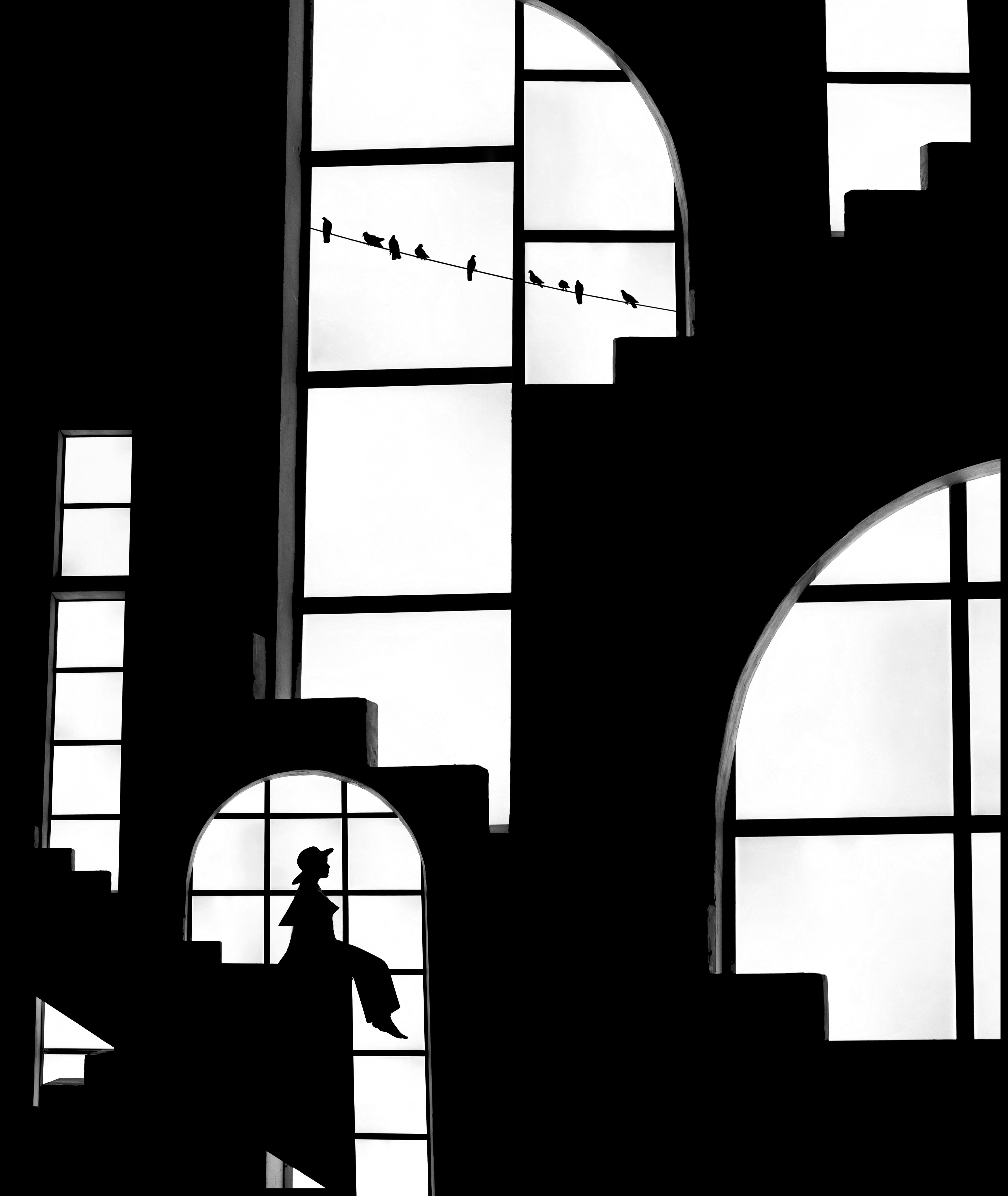 Silhouetted Figure on a Stairway Within a Geometric Glass Empire