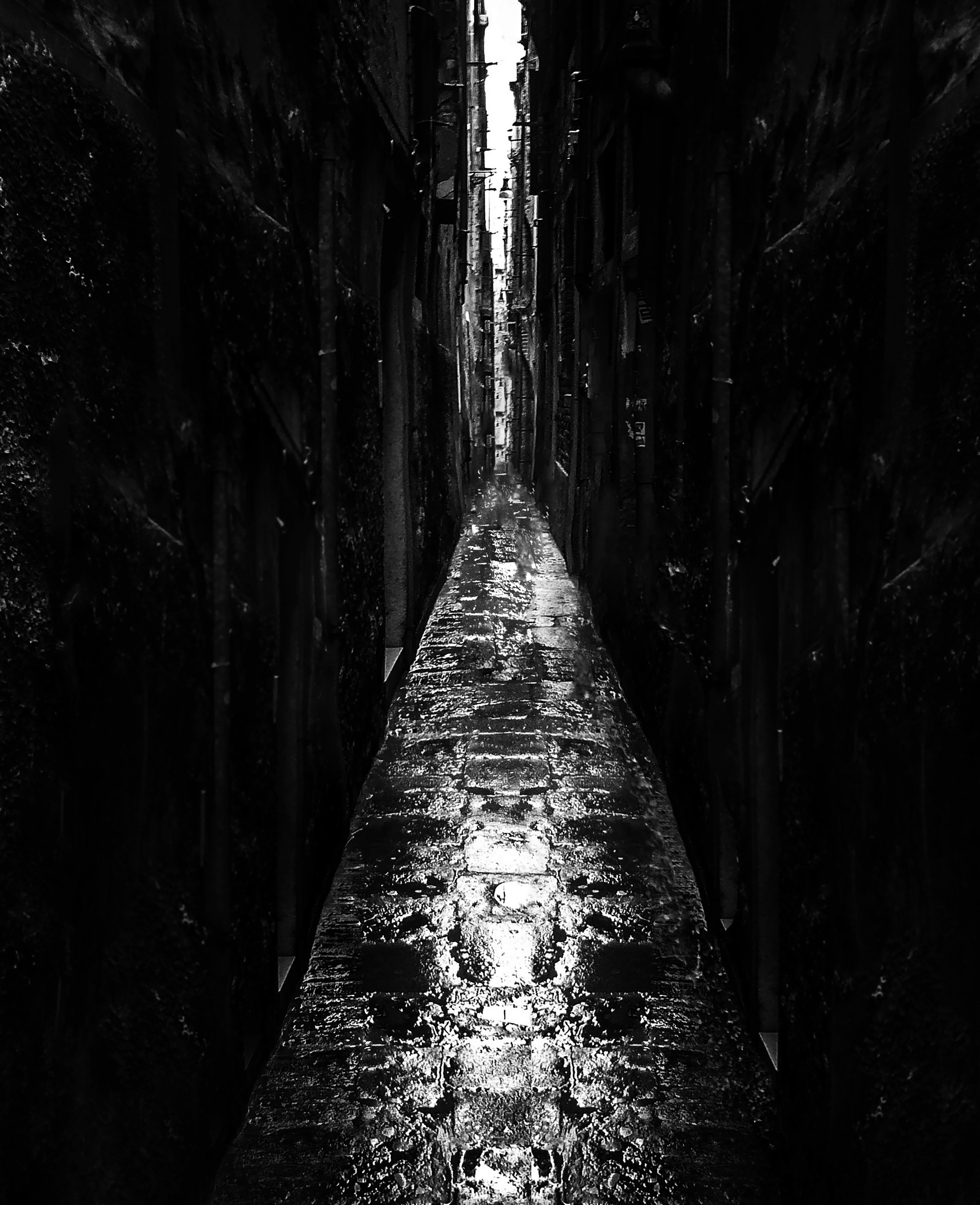 Dark, narrow alleyway leading to a bright light.