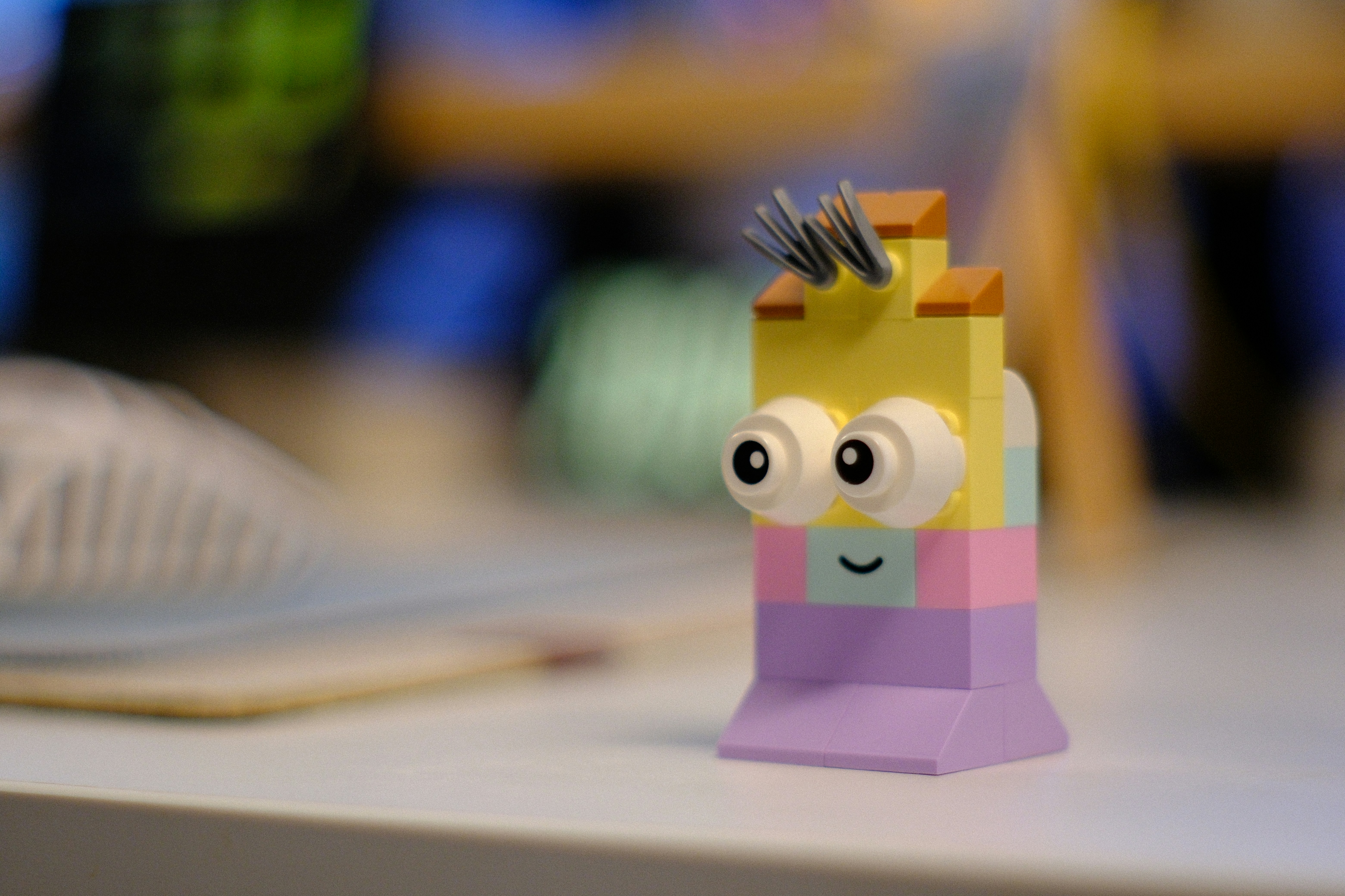 Lego Creature on a Quiet Desk: Whimsical Eye-Contact