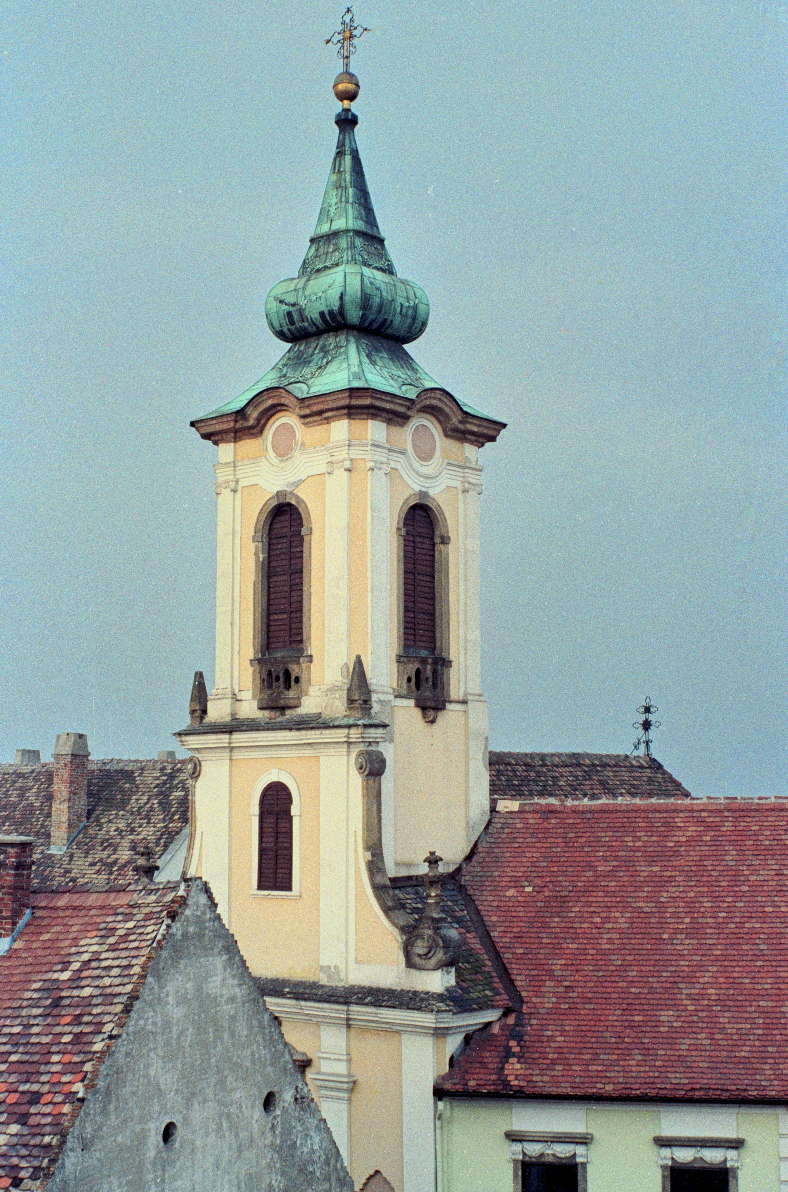 Clocktower in Soft Light: A Baroque Spur Rises Above Red Tile Roofs