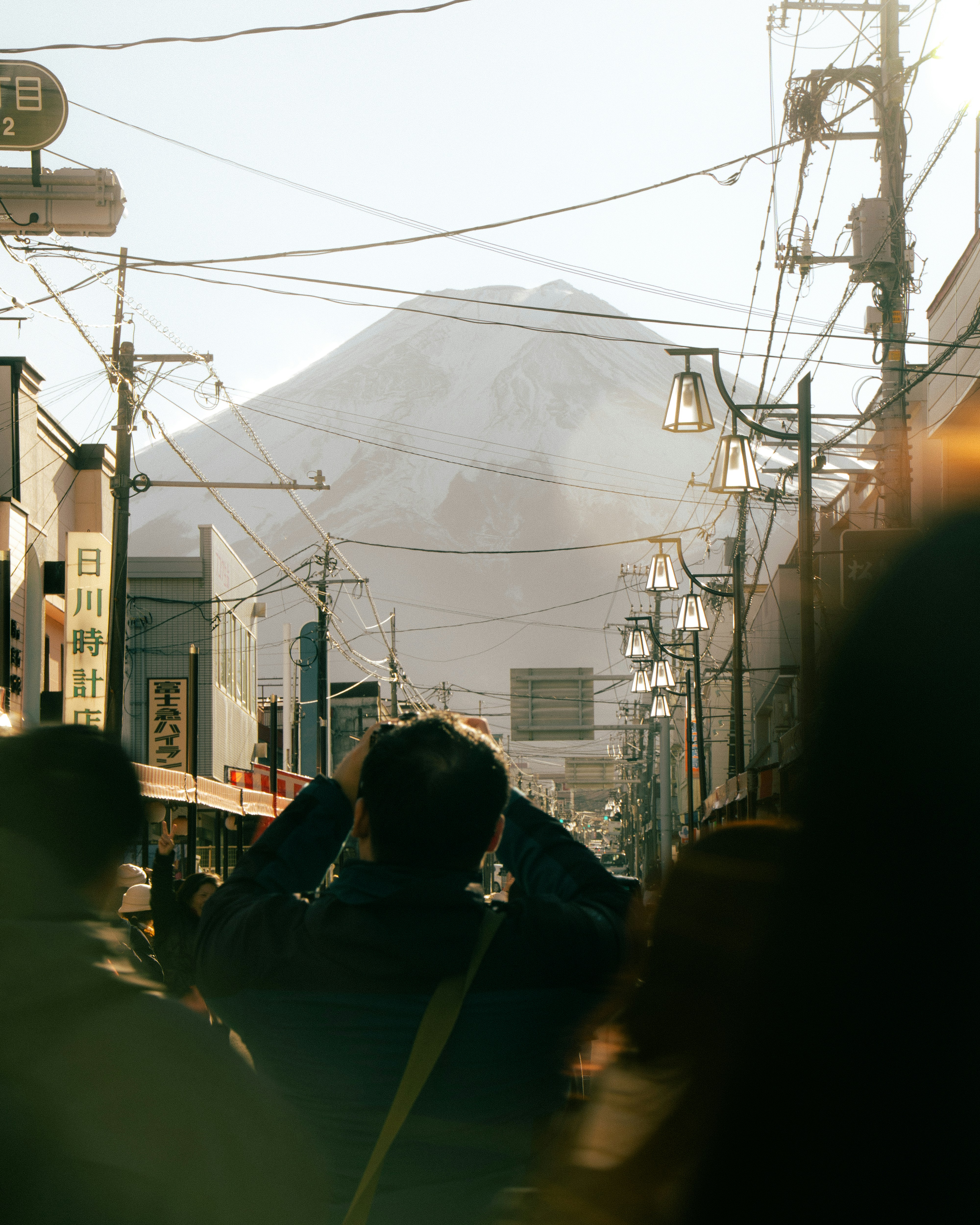 Street toward Mount Fuji: A crowded urban path beneath electric lines