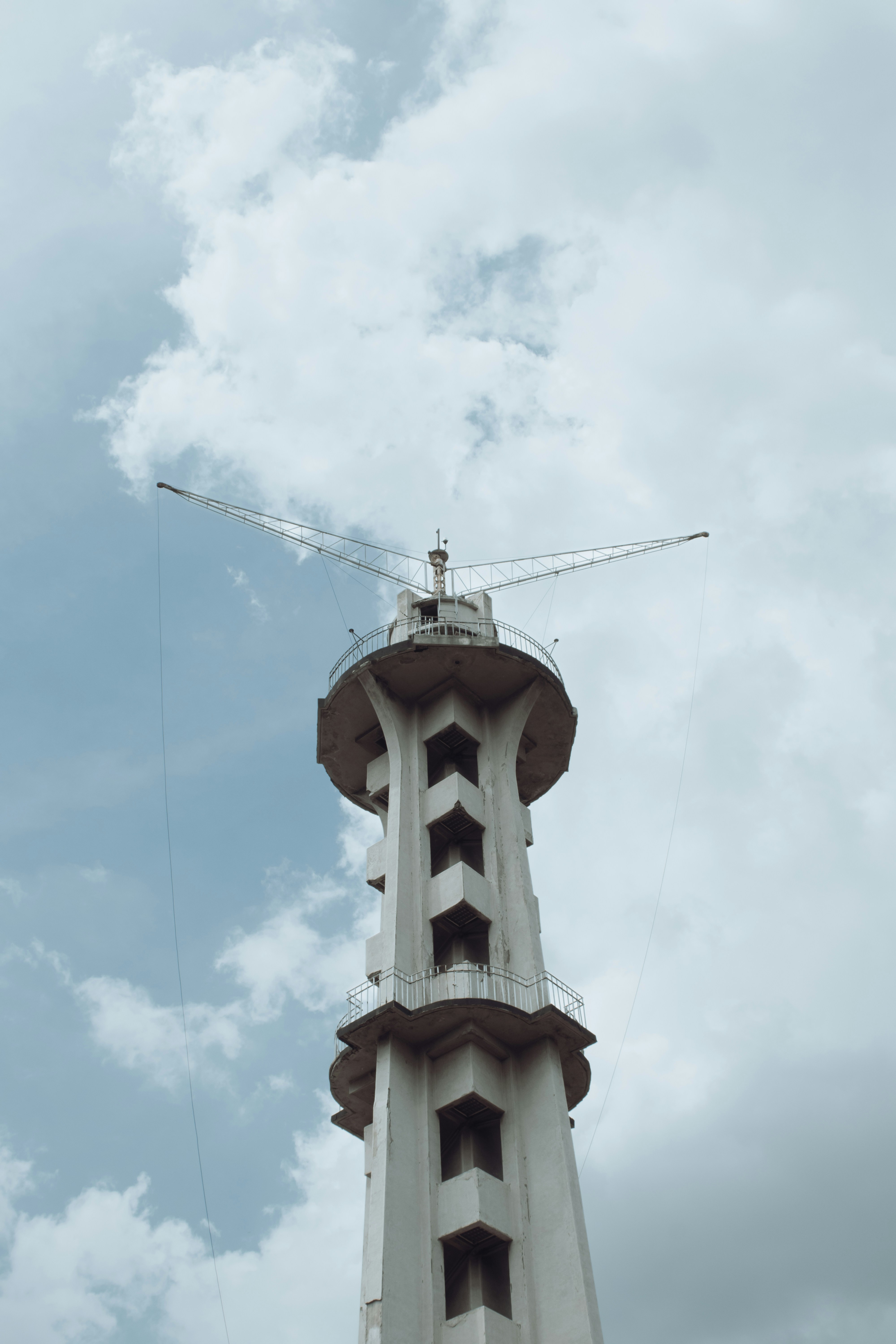 Crane-Topped Lighthouse Tower Reaching Toward a Clear Sky