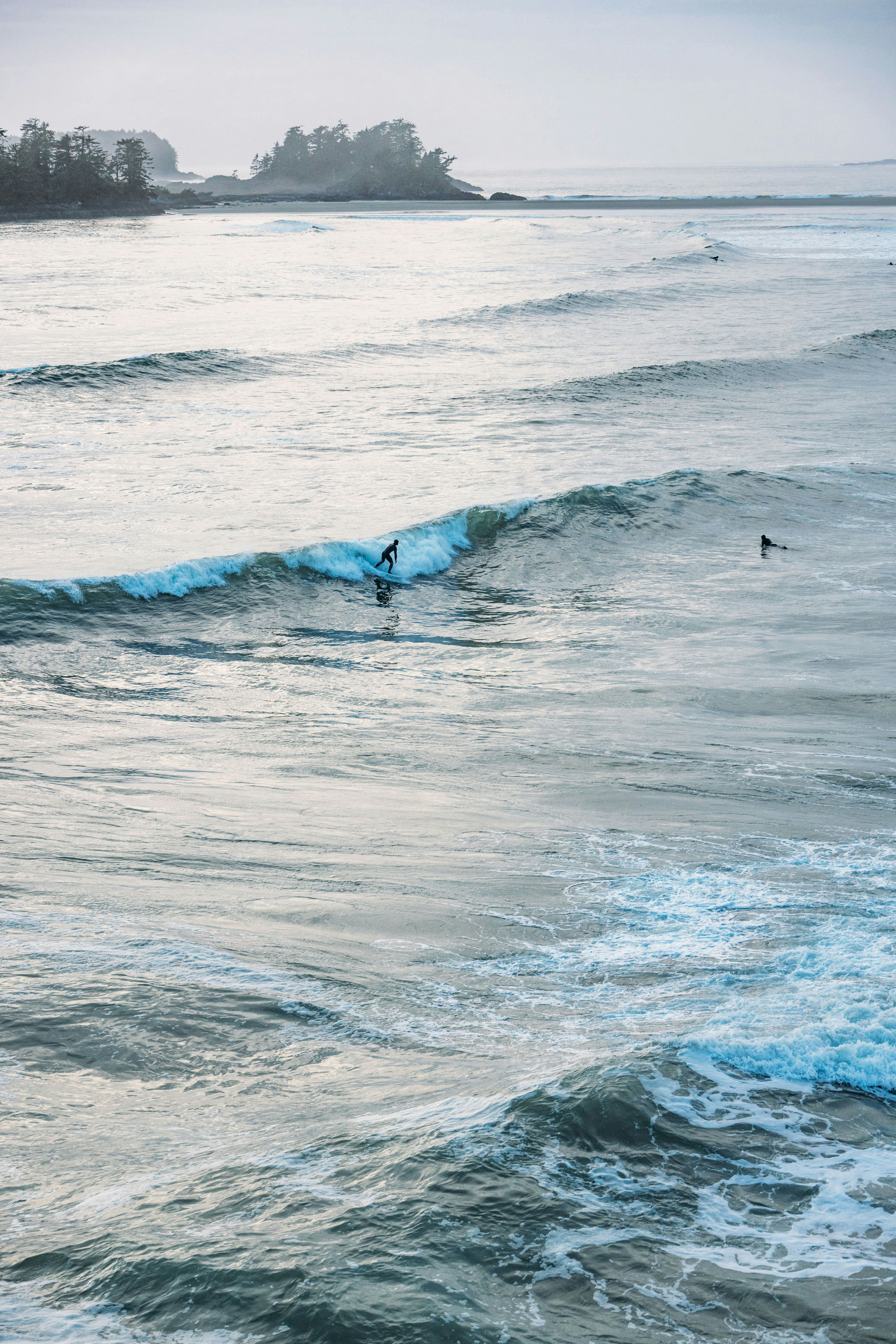 Incoming Azure Crest: Surfer carving a turquoise wave under a broad coastal horizon