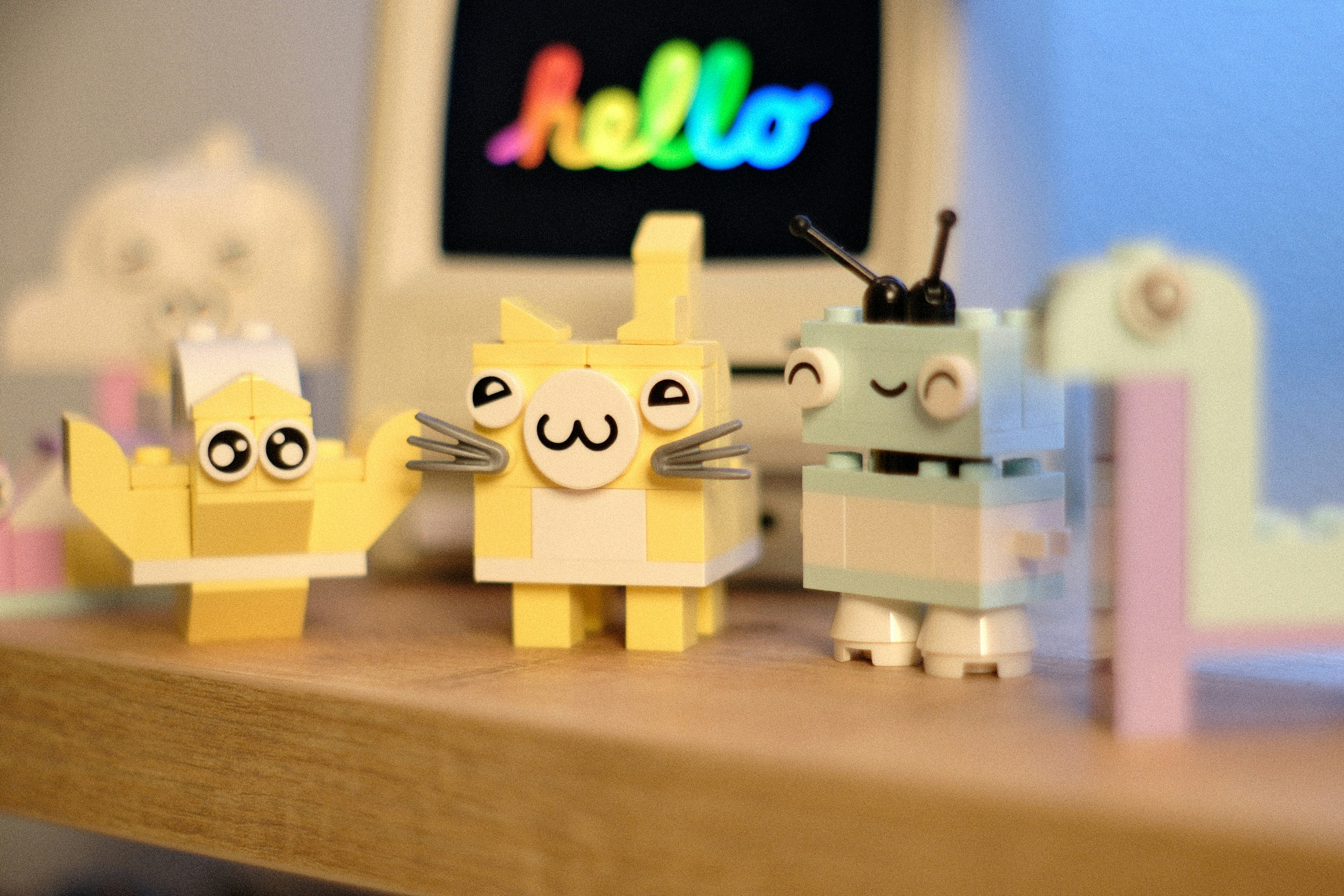 Three cute lego figures stand on a shelf with