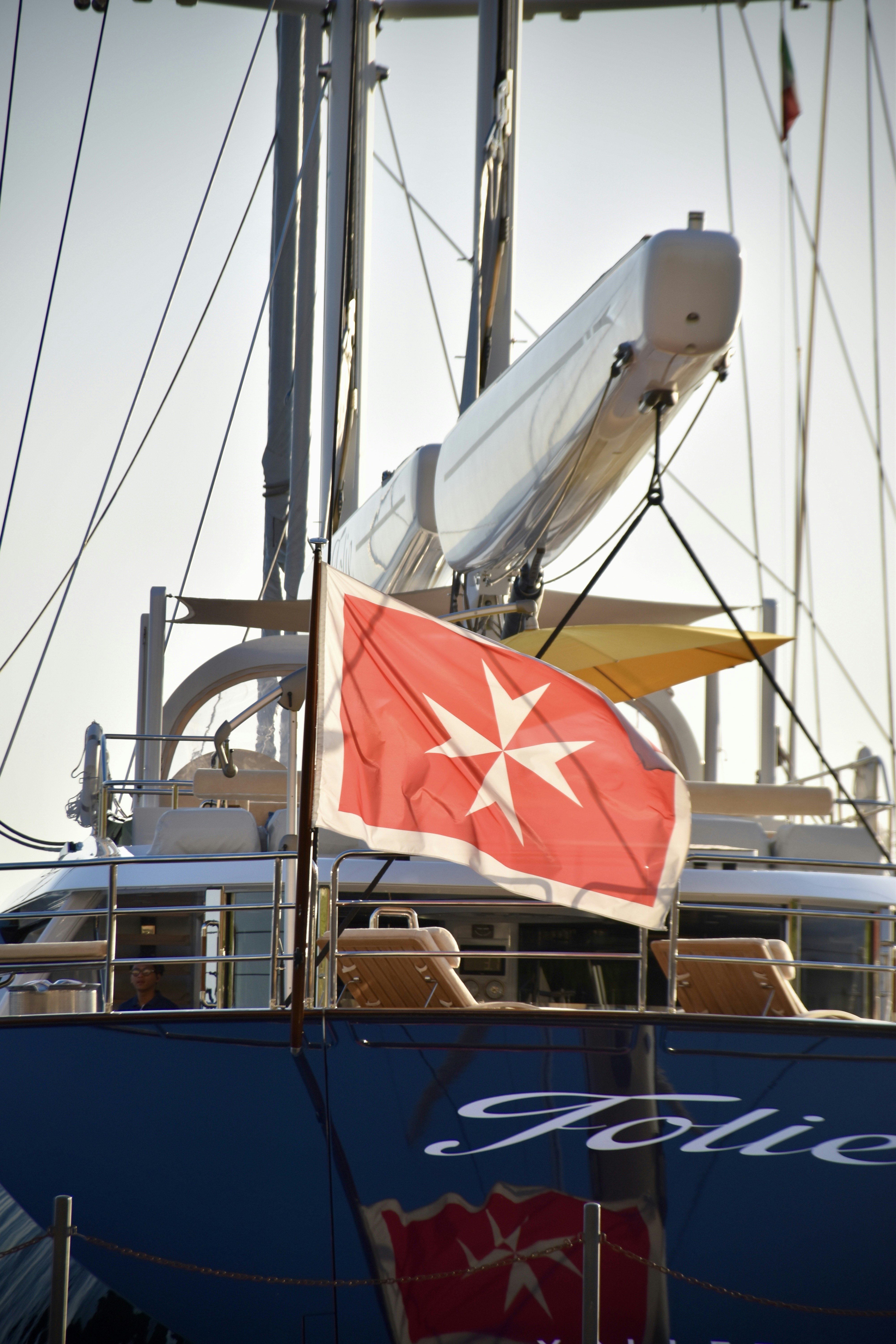 Sailing Vessel Portrait: Red Flag and Mast Lines Framed by Blue Hull
