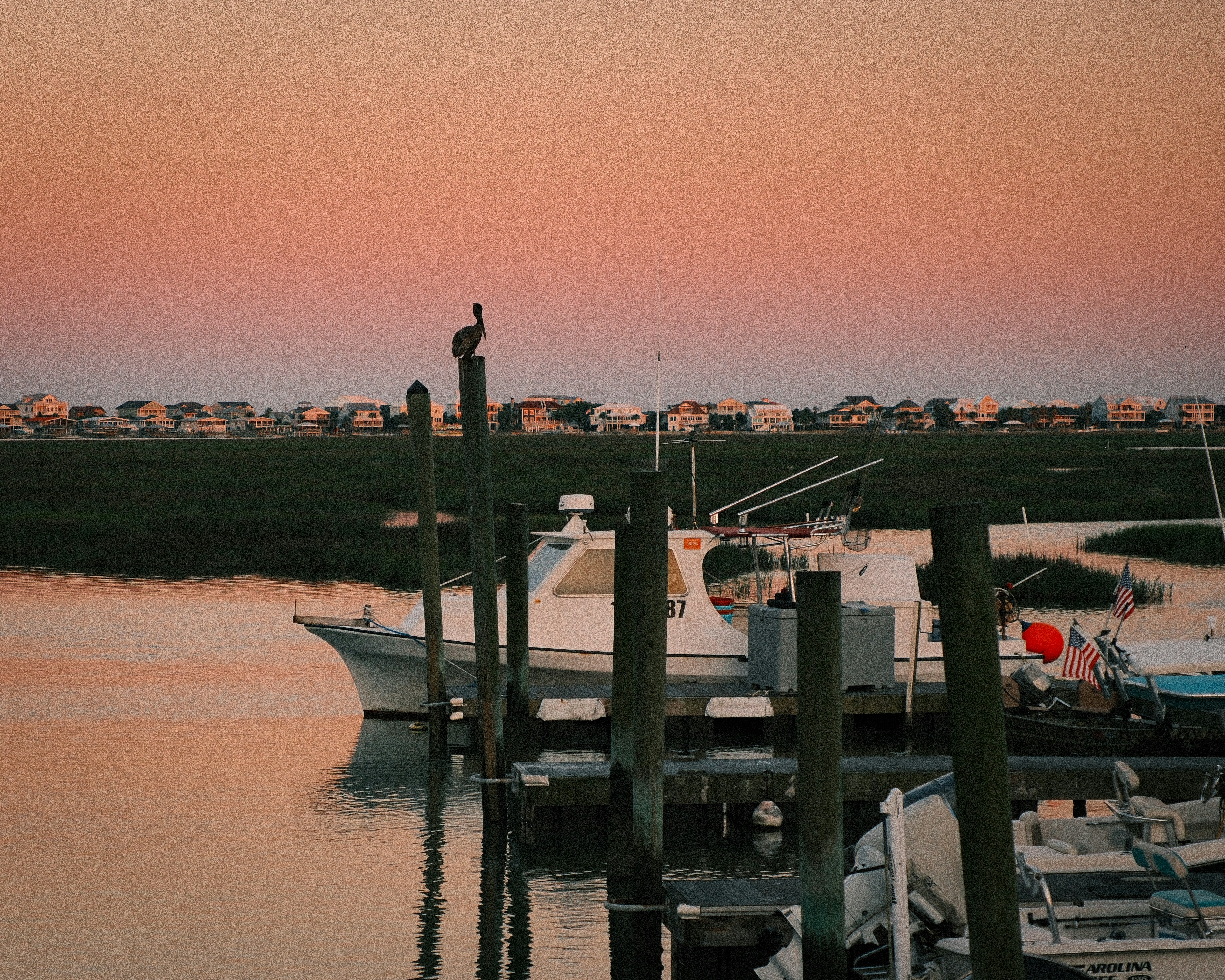 Sunset Quiet: Boats, Piers, and a Leaning Heron at Dusk