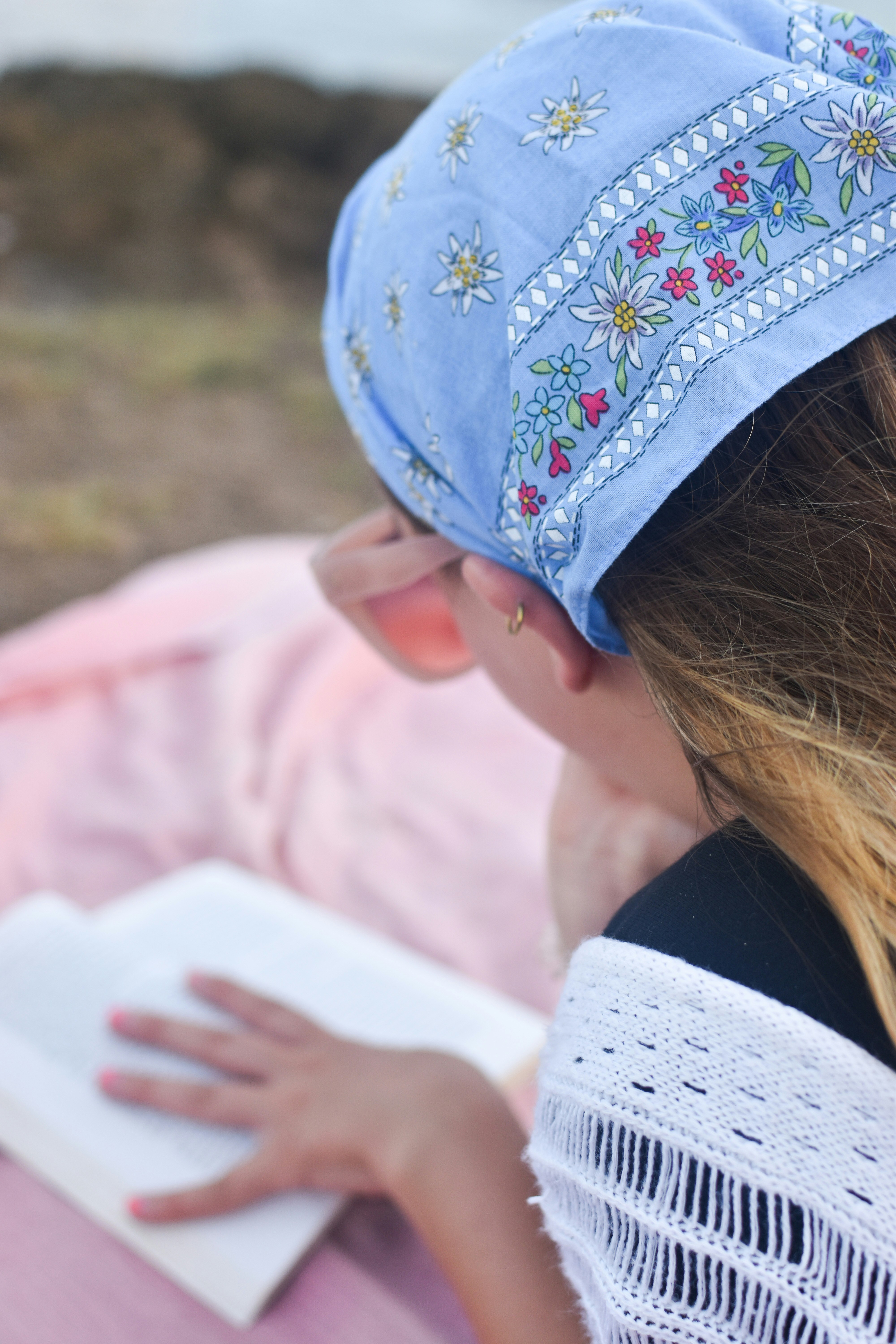 Quiet Focus: A Girl Reading Beside a Painted Bandana