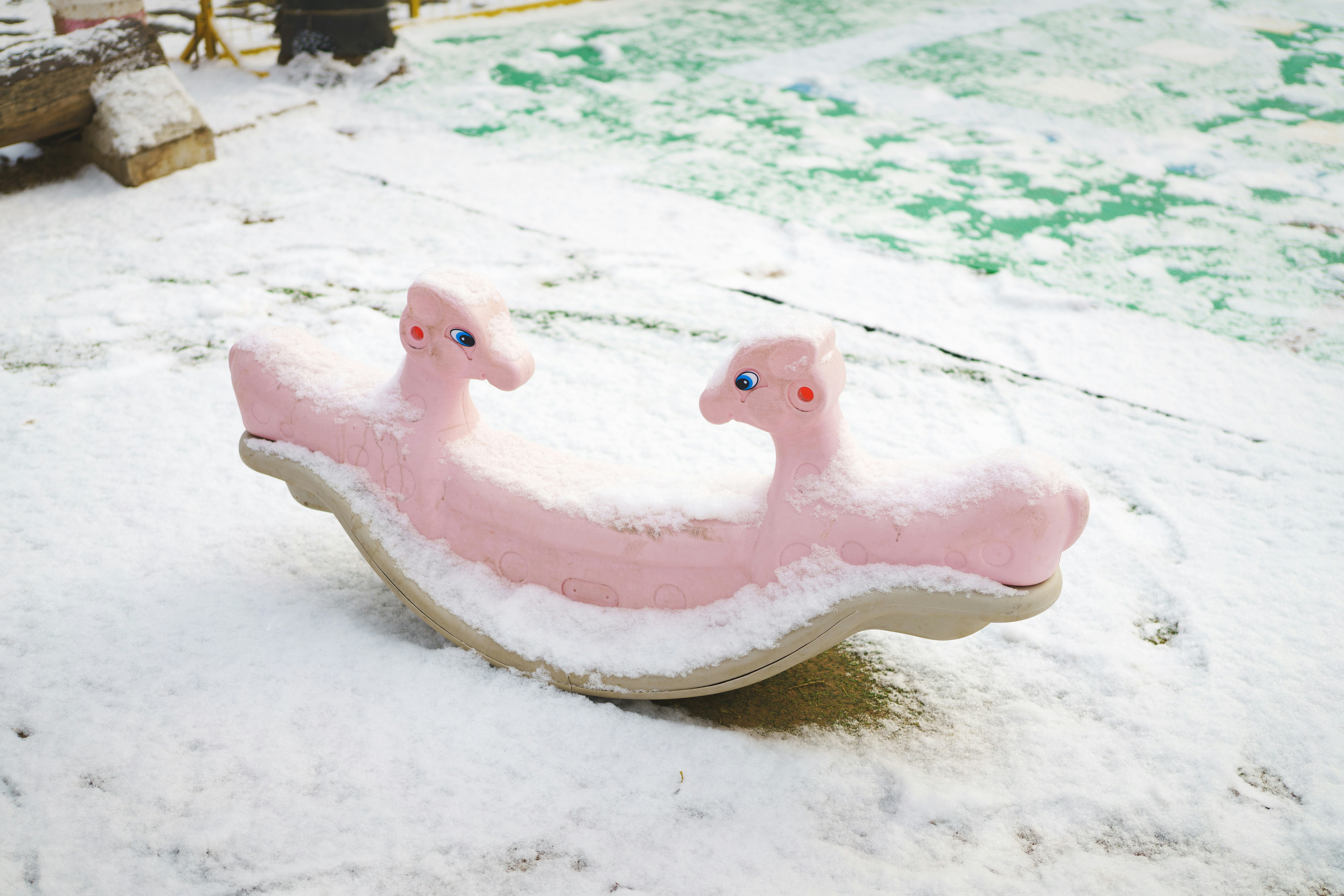Twin pink ducks on a snowy stage by a frosted pool
