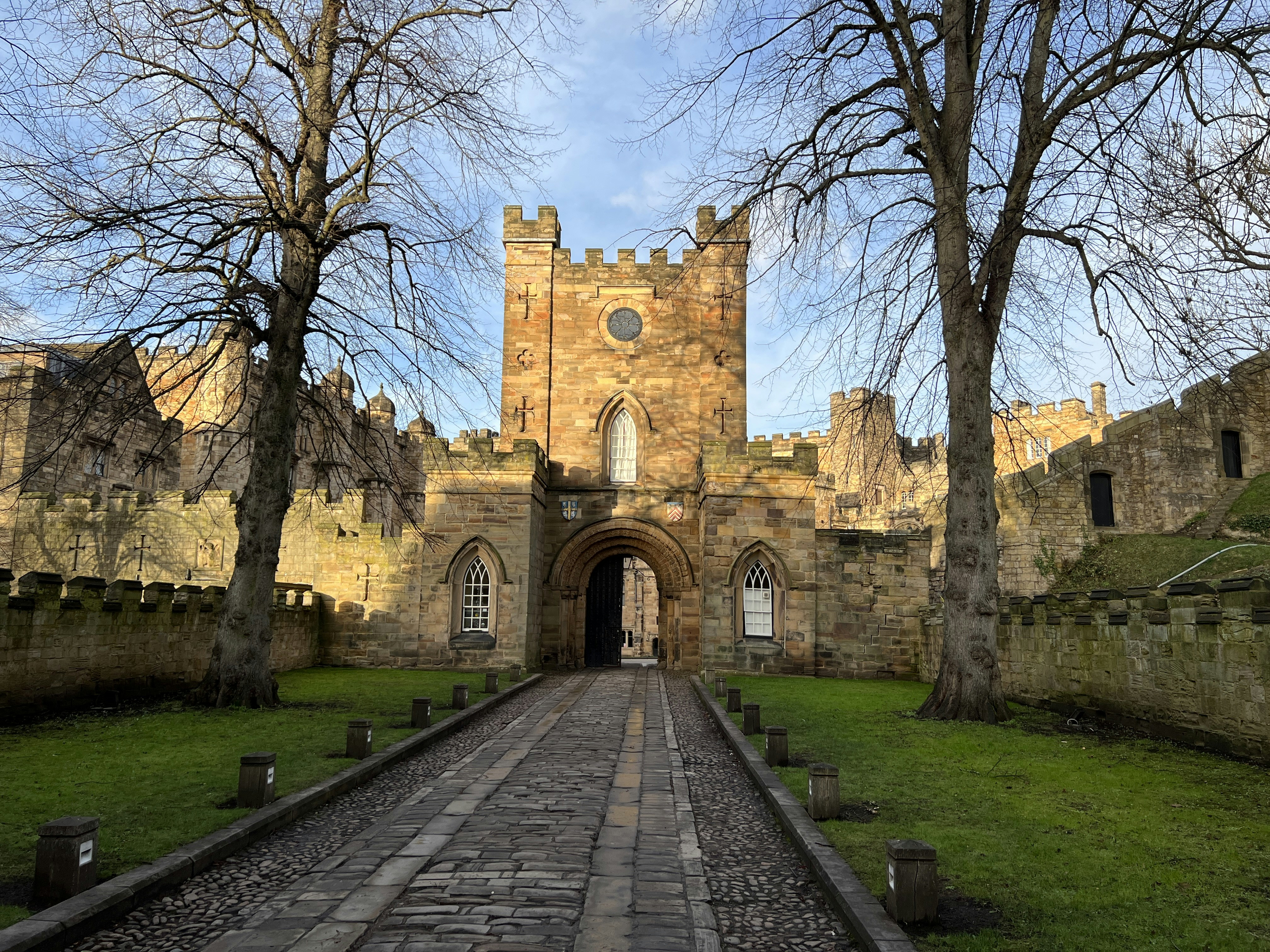 Winding stone pathway leads to an imposing castle-like structure set amidst the picturesque University College campus at Durham.