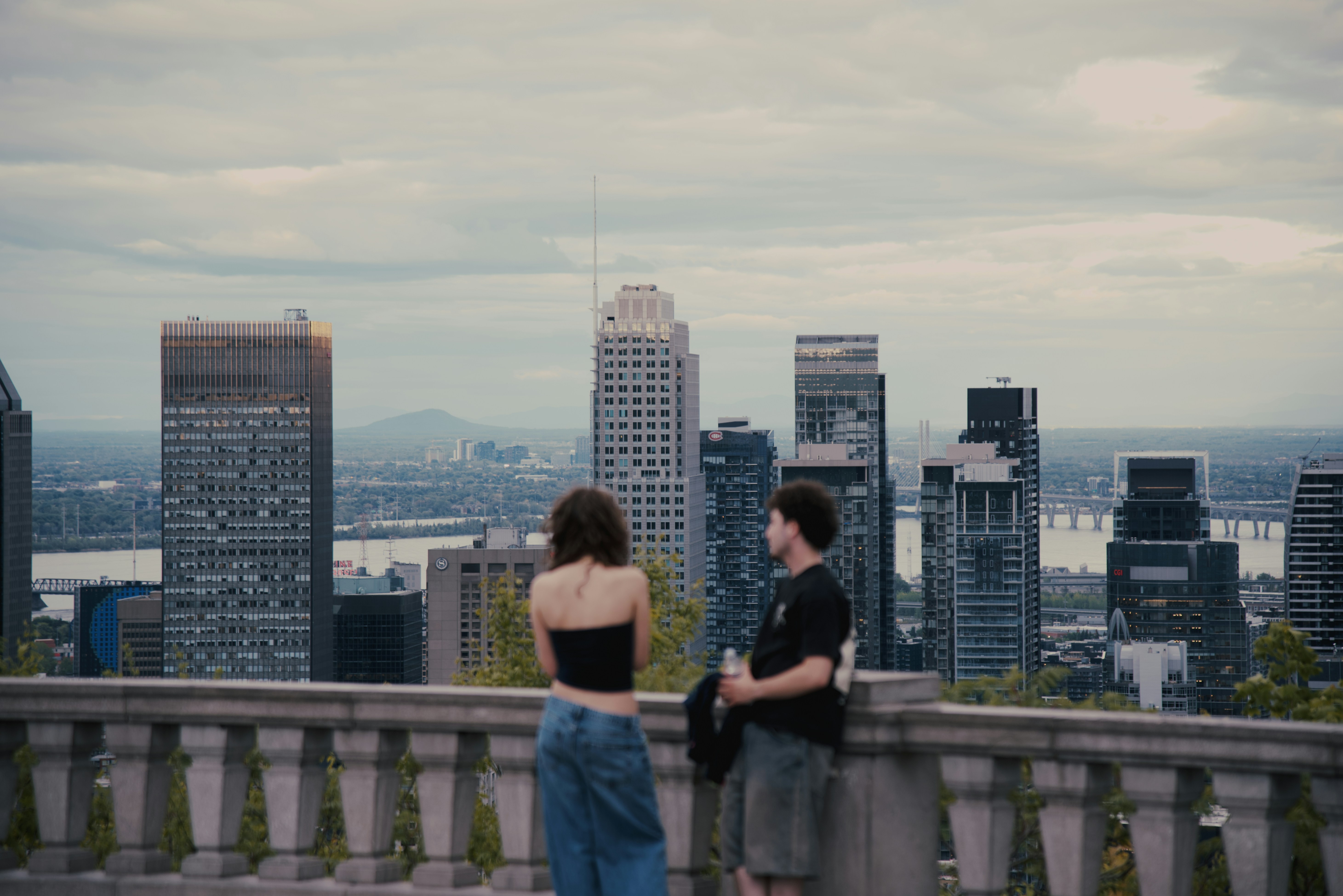 Two Figures on a City Vista: Quiet Conversation Against a Skyscraper Skyline