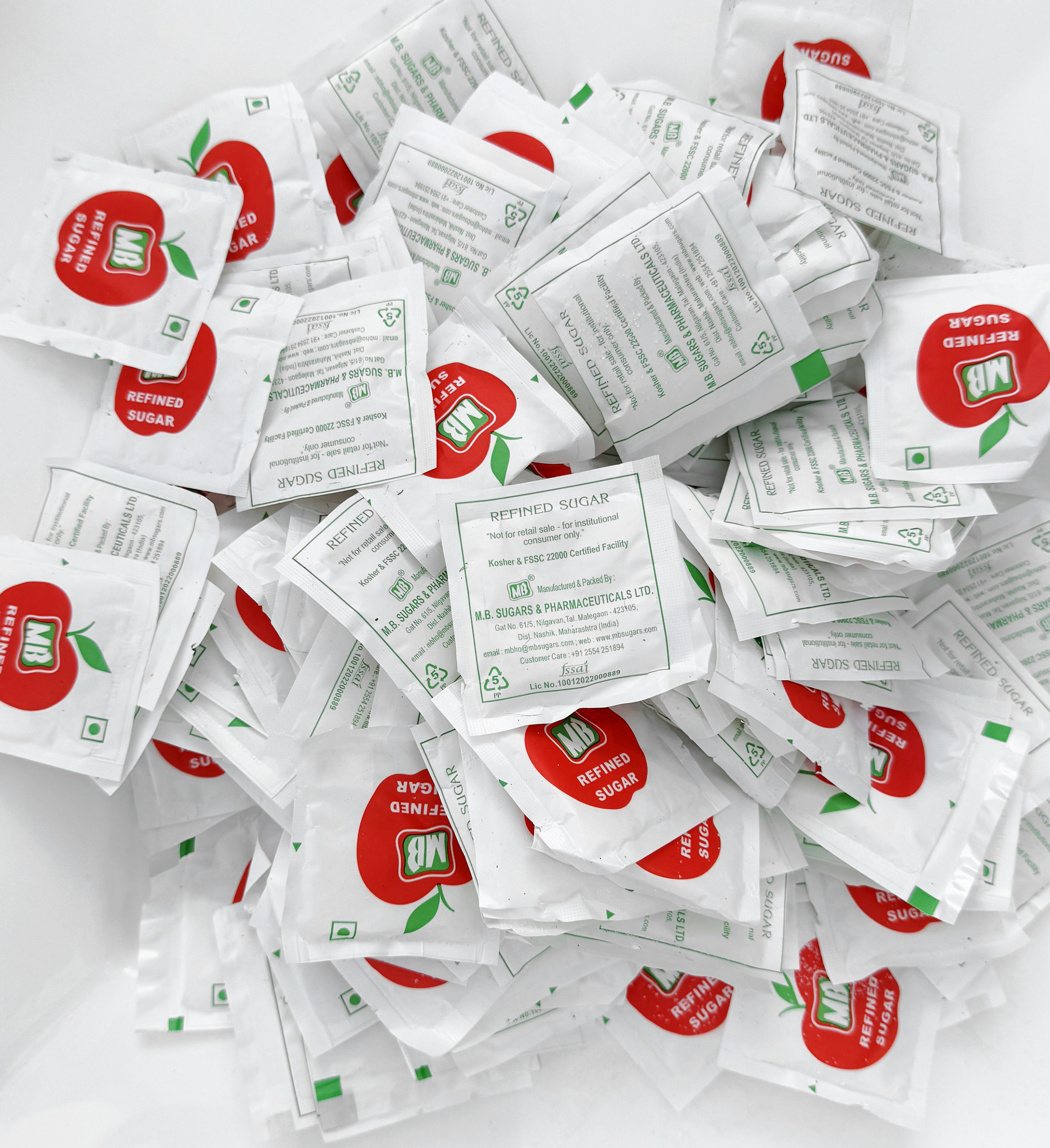 A Sea of Sweeteners: Close-Up of White Sugar Packets with Red Apple Logos