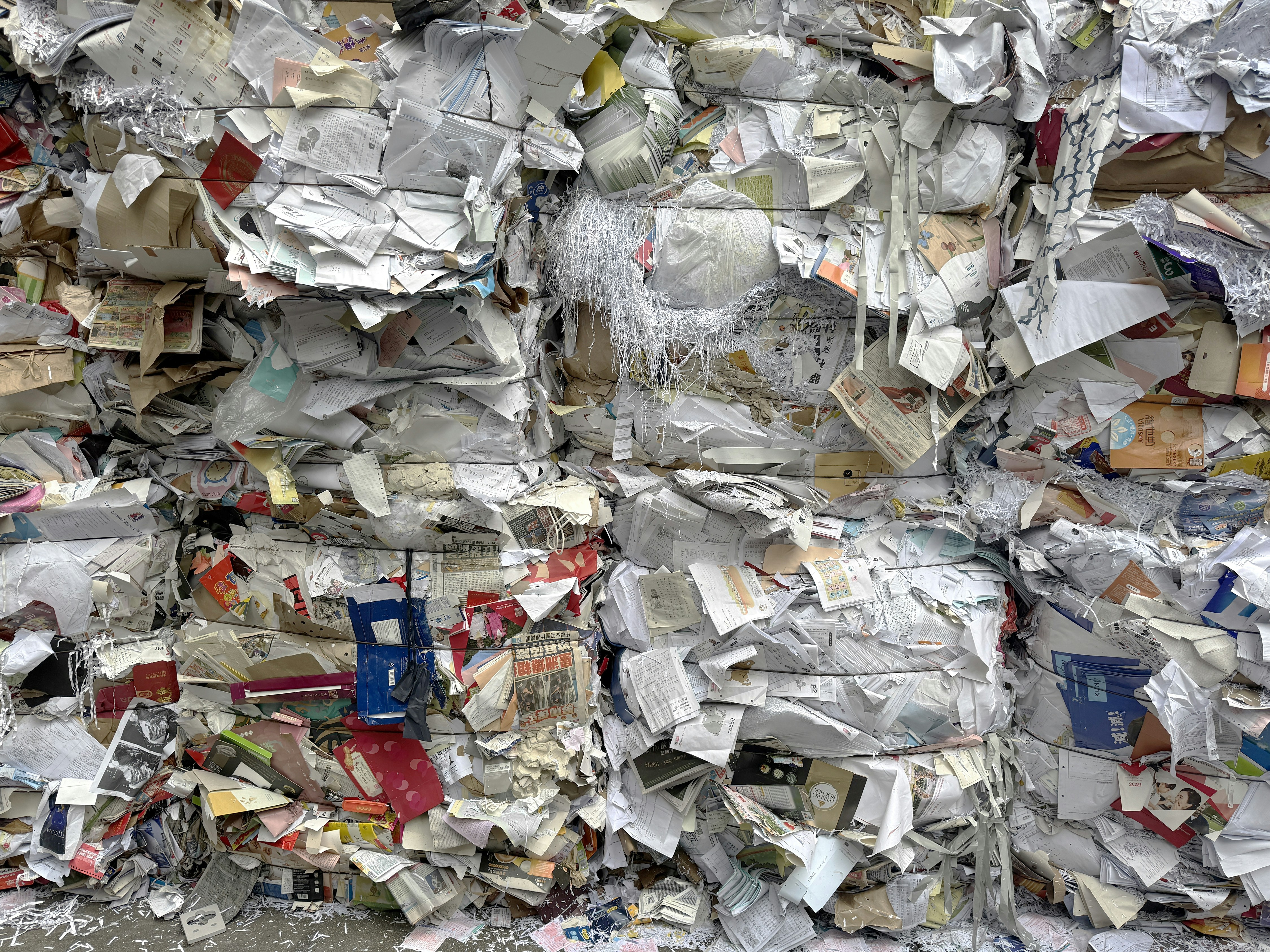 Heaps of paper at a recycling facility waiting to be picked up.