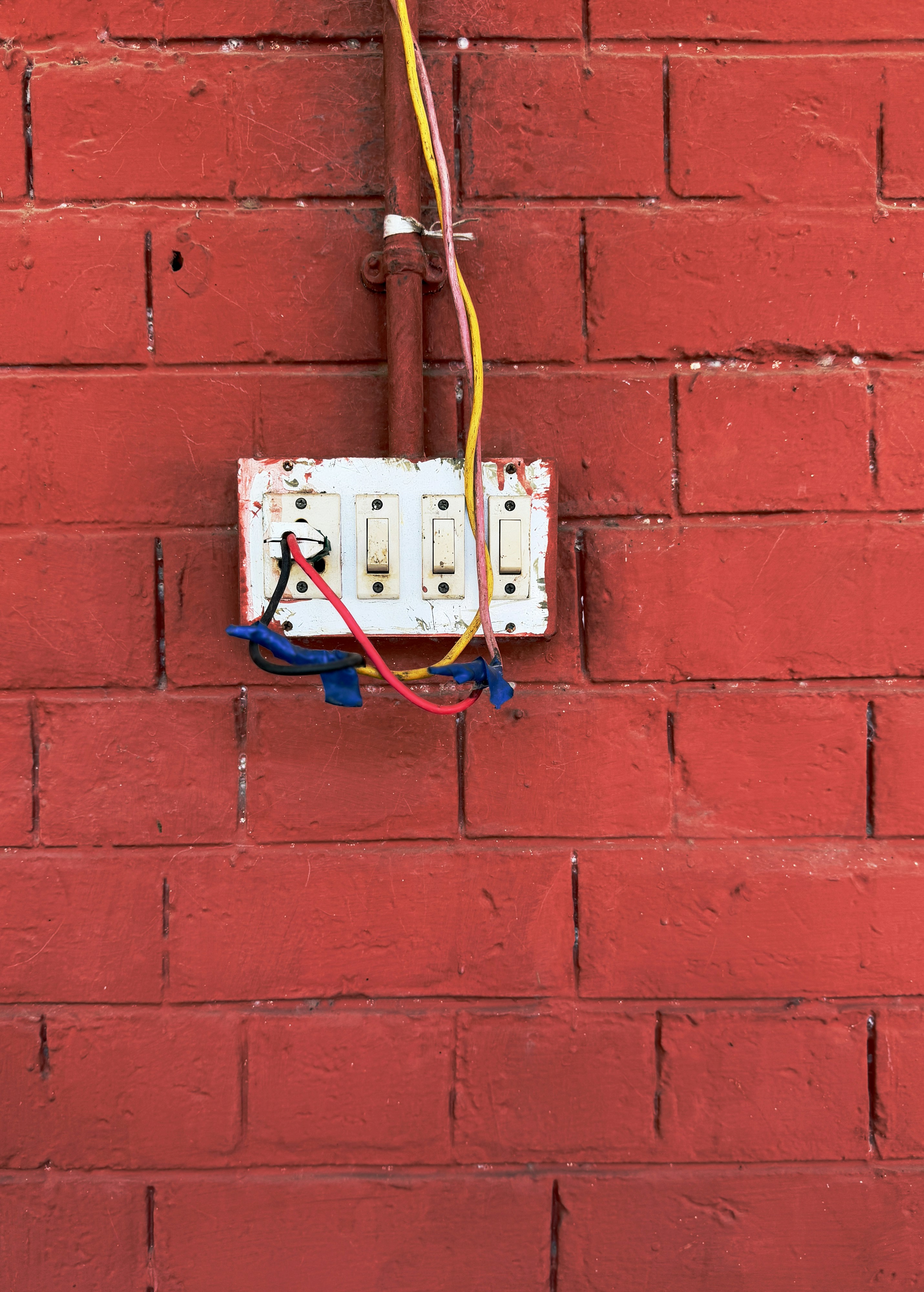 Electrical Ring of Color Against a Crimson Brick Facade