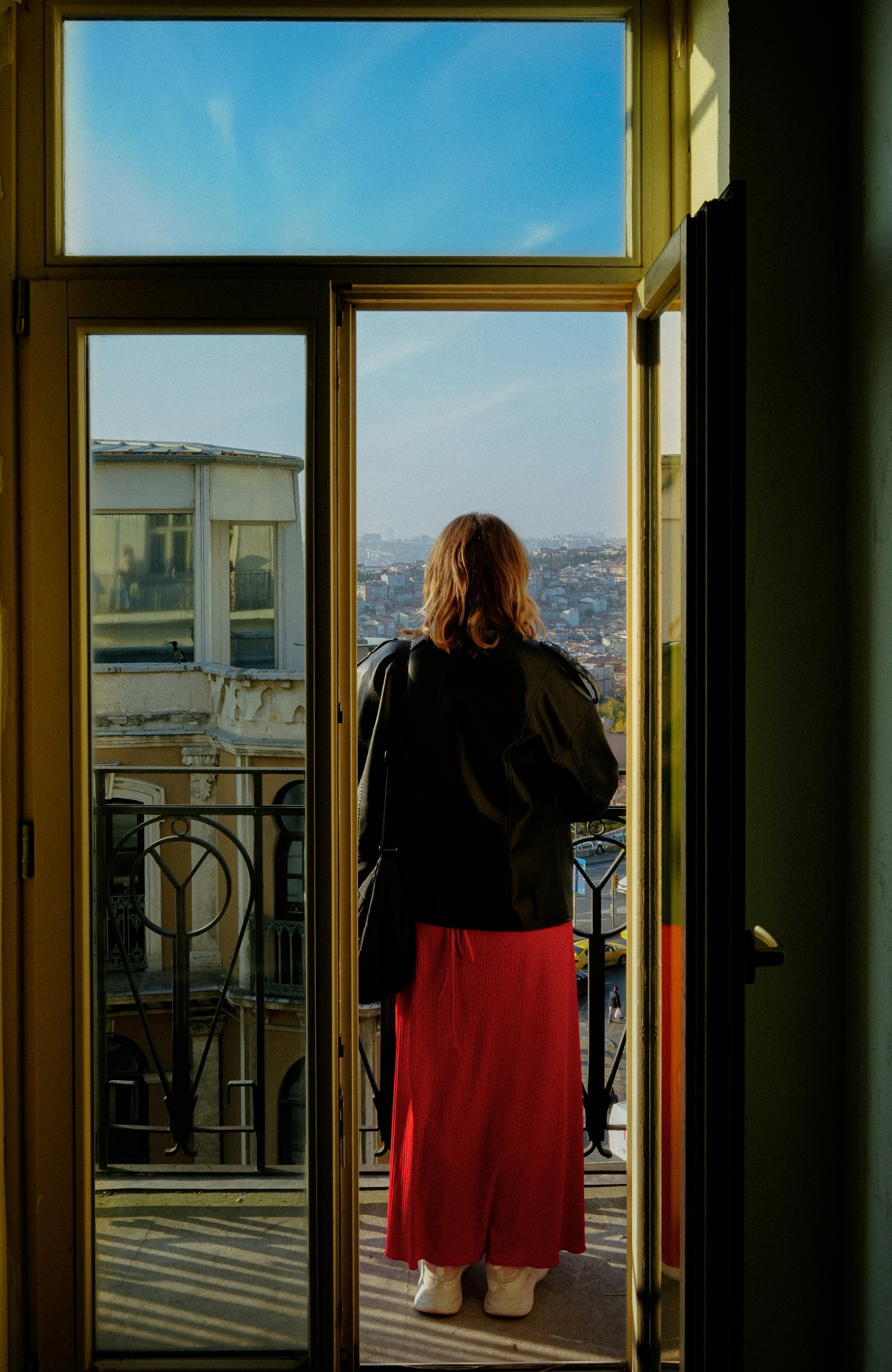 Balcony Gaze: A Woman in Red at Dusk Window