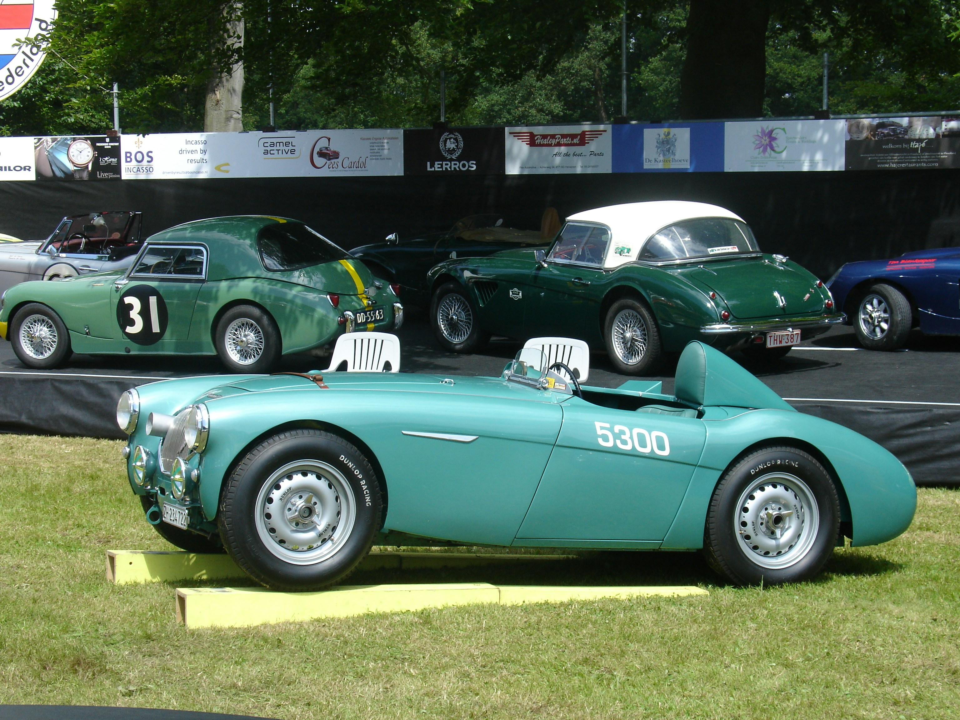 Turquoise Open-Waired Racer: A Row of Vintage Cars at Rest