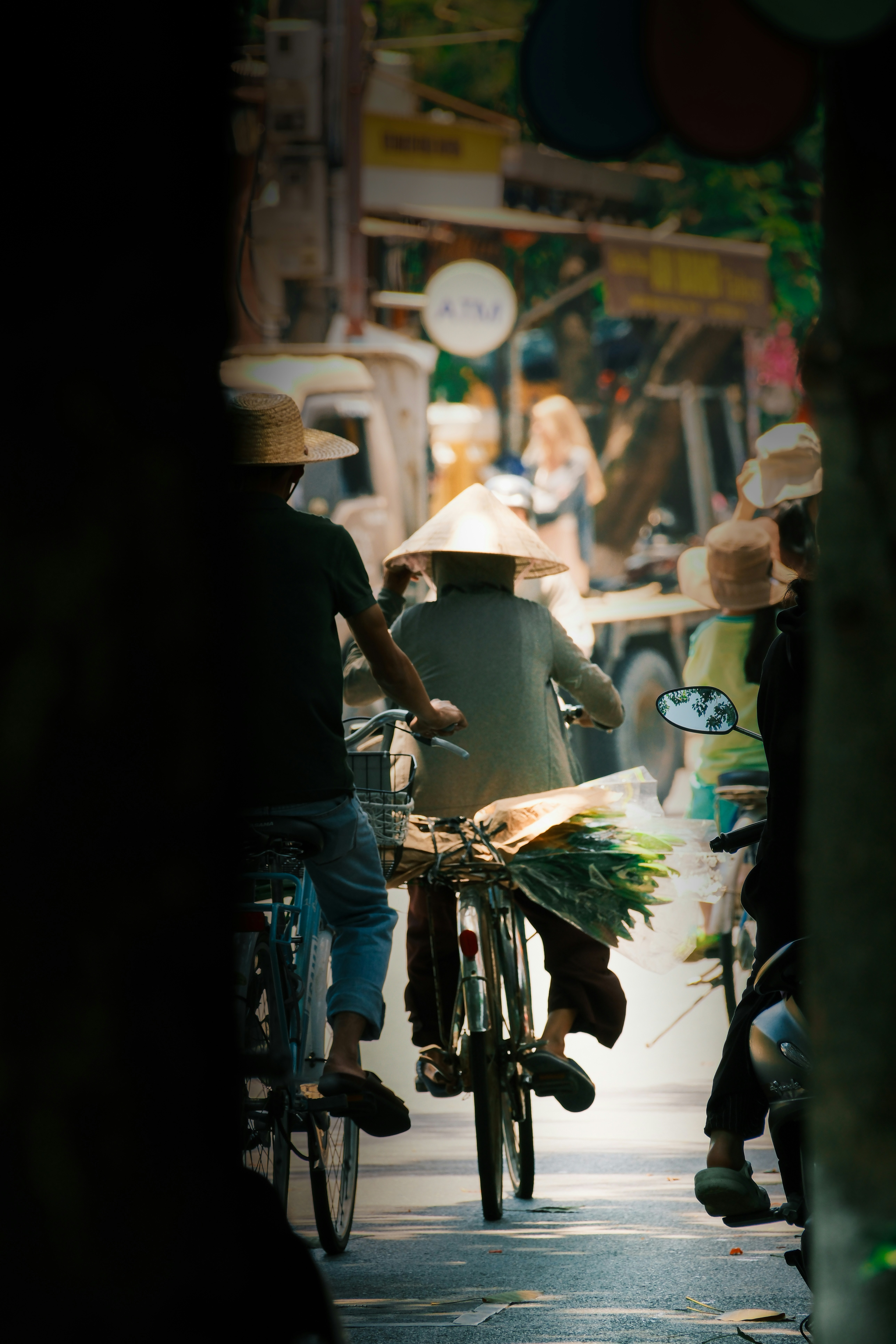 Beneath the Market Canopy: Bicycles and Straw Hats in a Sunlit Alley
