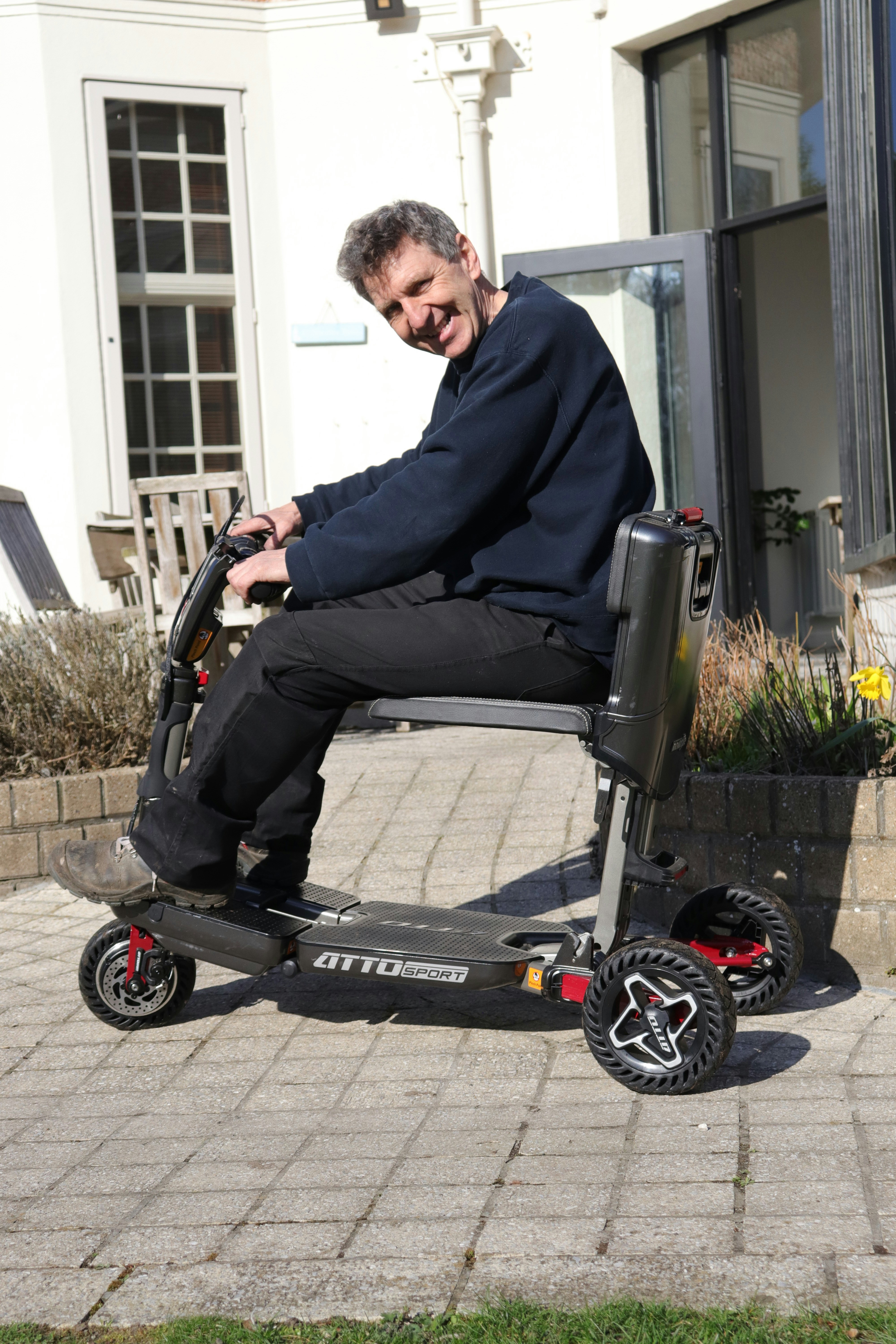Signal of Resilience: A Man in a Mobility Scooter Enjoys a Sunlit Morning