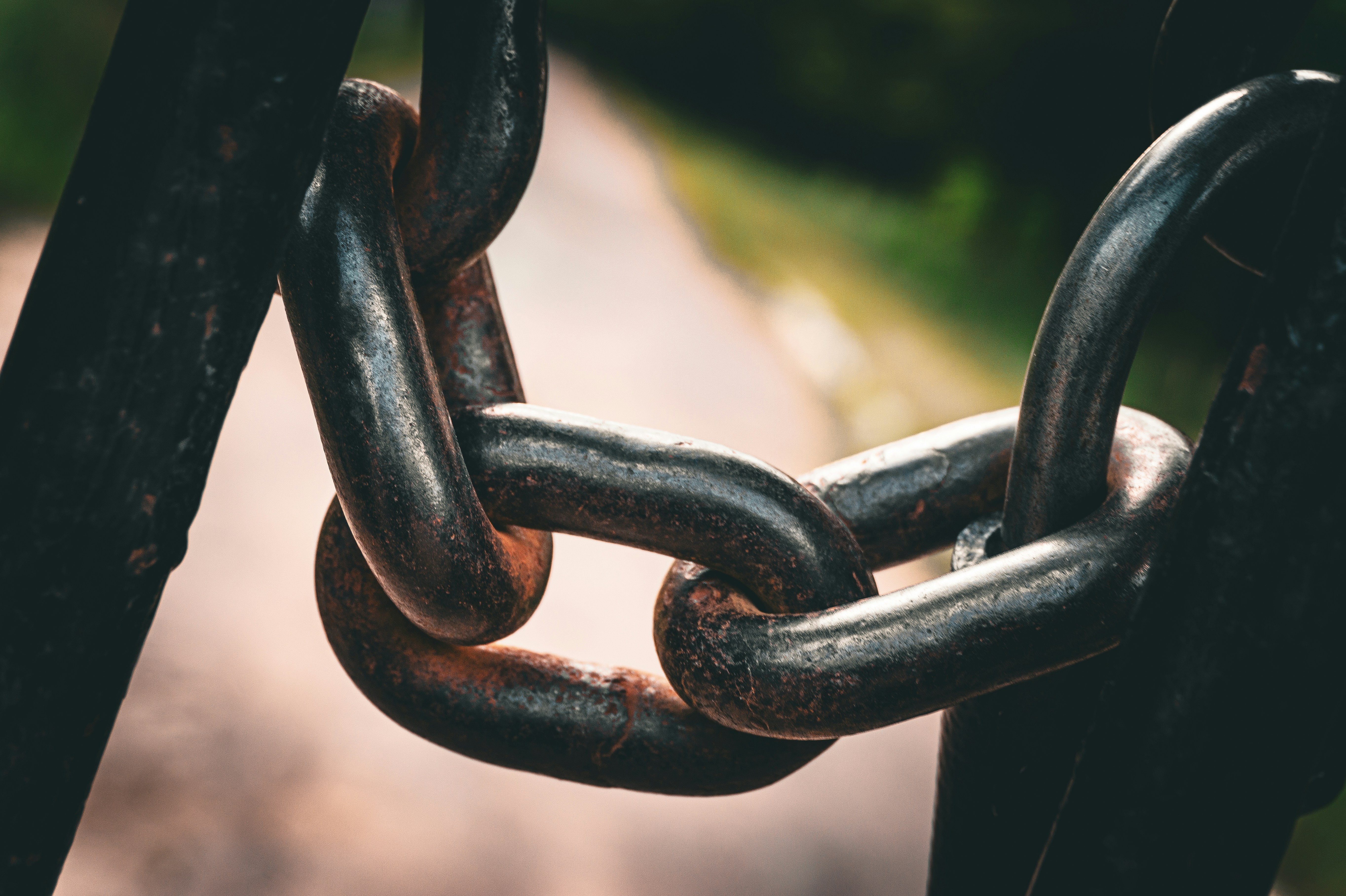 Linked in Rust: a close-up of weathered chains on a sunlit path