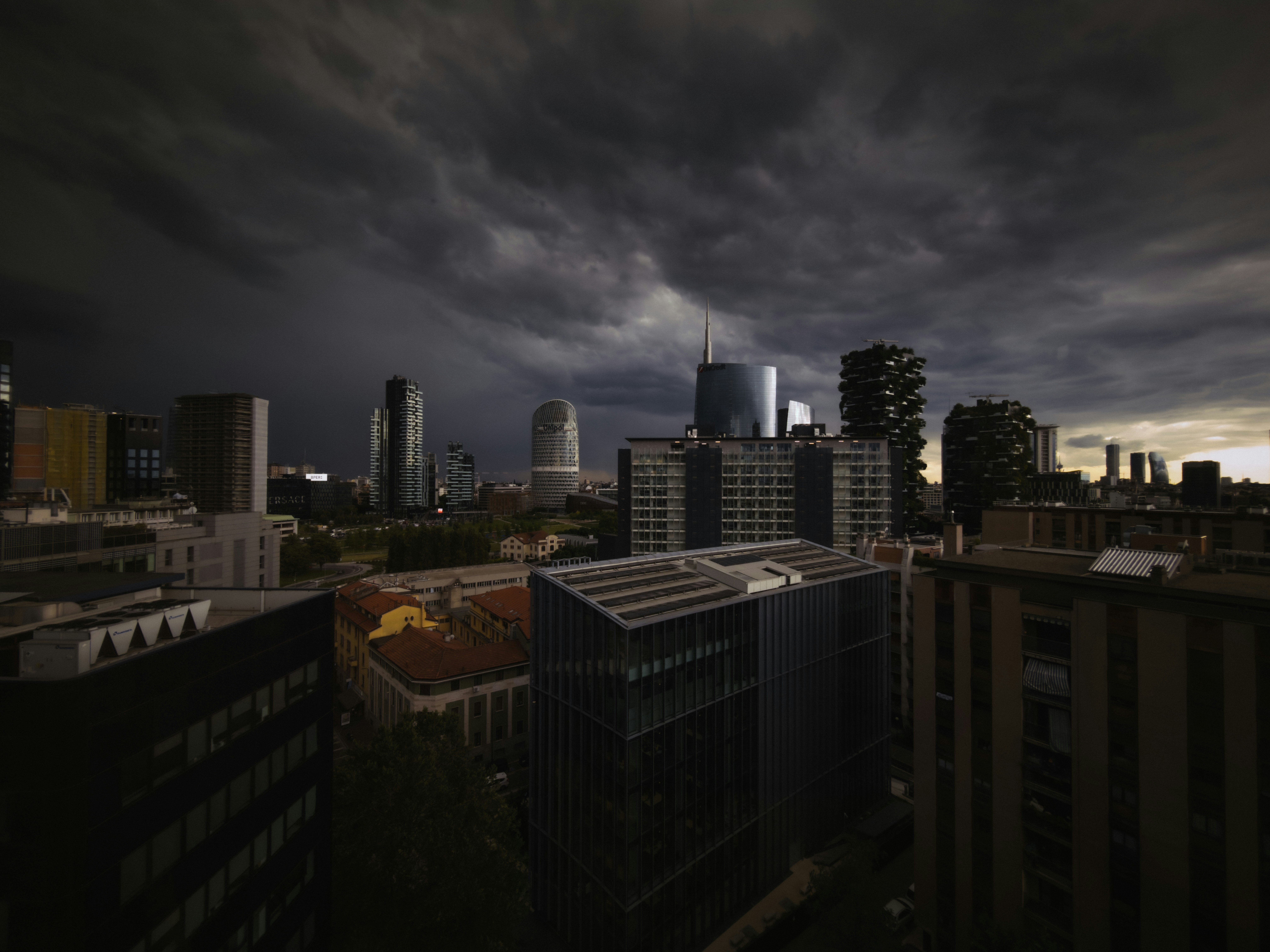 Dark, stormy clouds loom over a modern city skyline