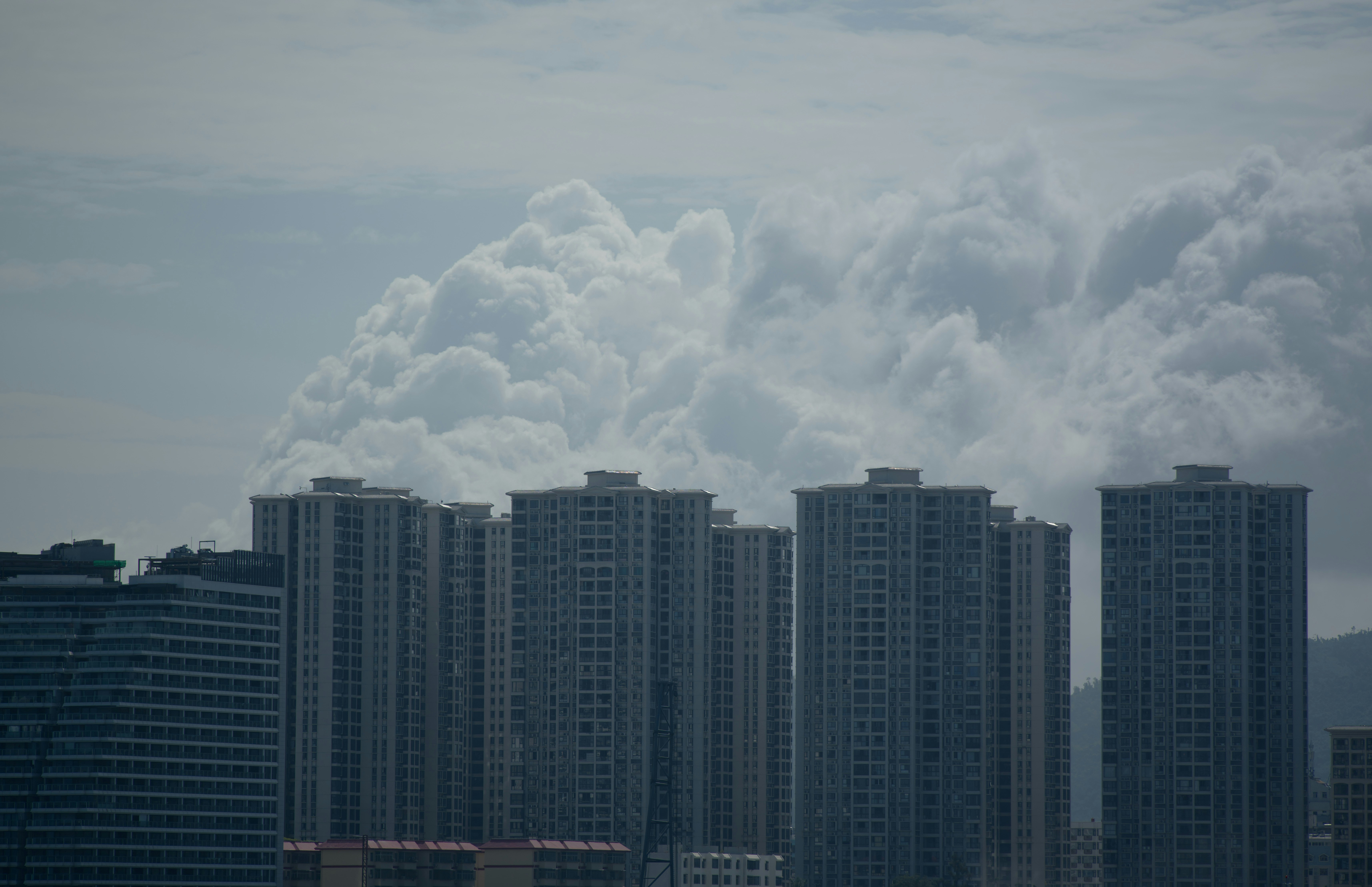 Rising Ridges: Concrete Towers Against a Sky of Puffy Clouds