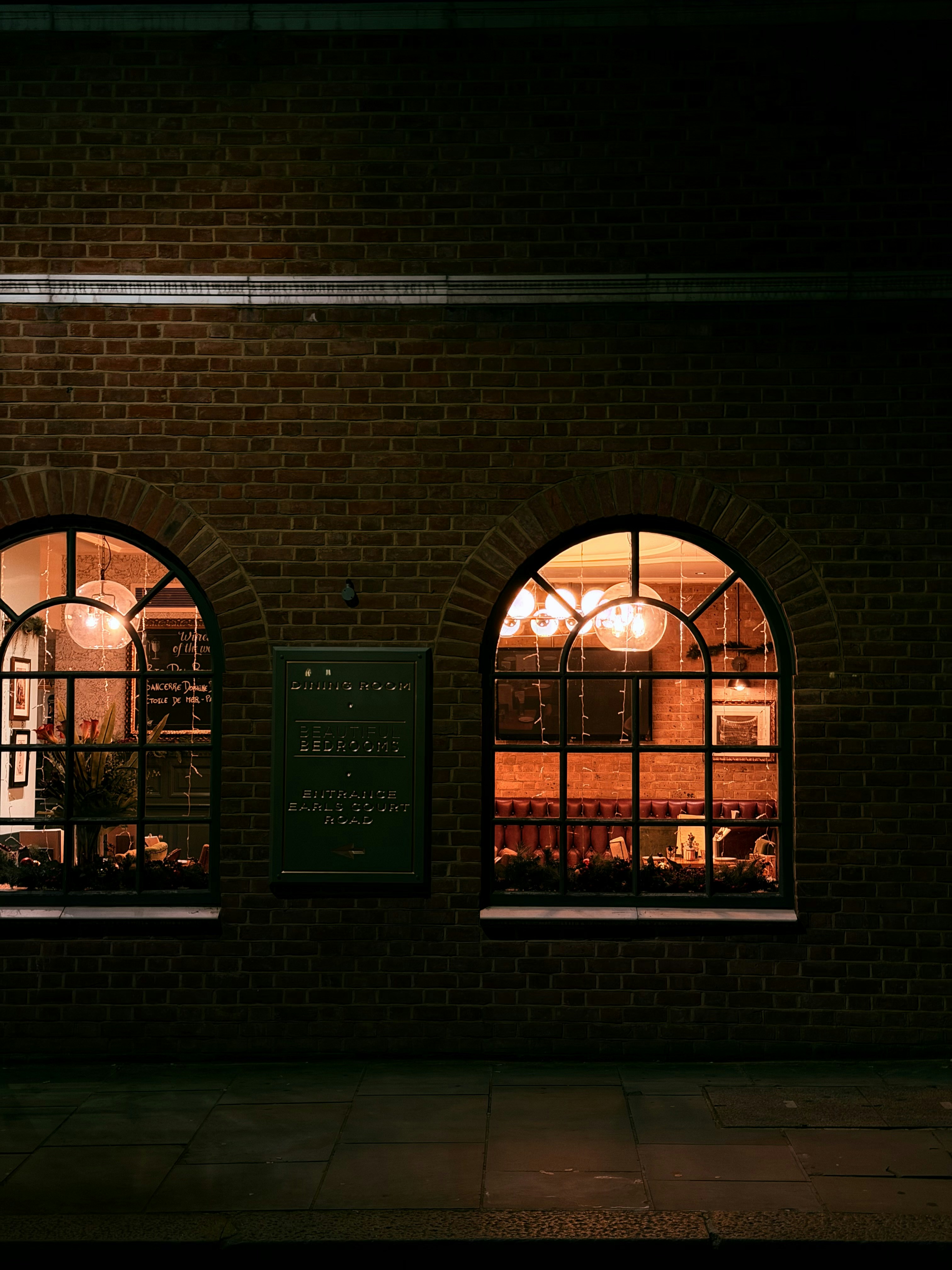 Warm Arches, Quiet Night: A Brick Café Glows Through Glass