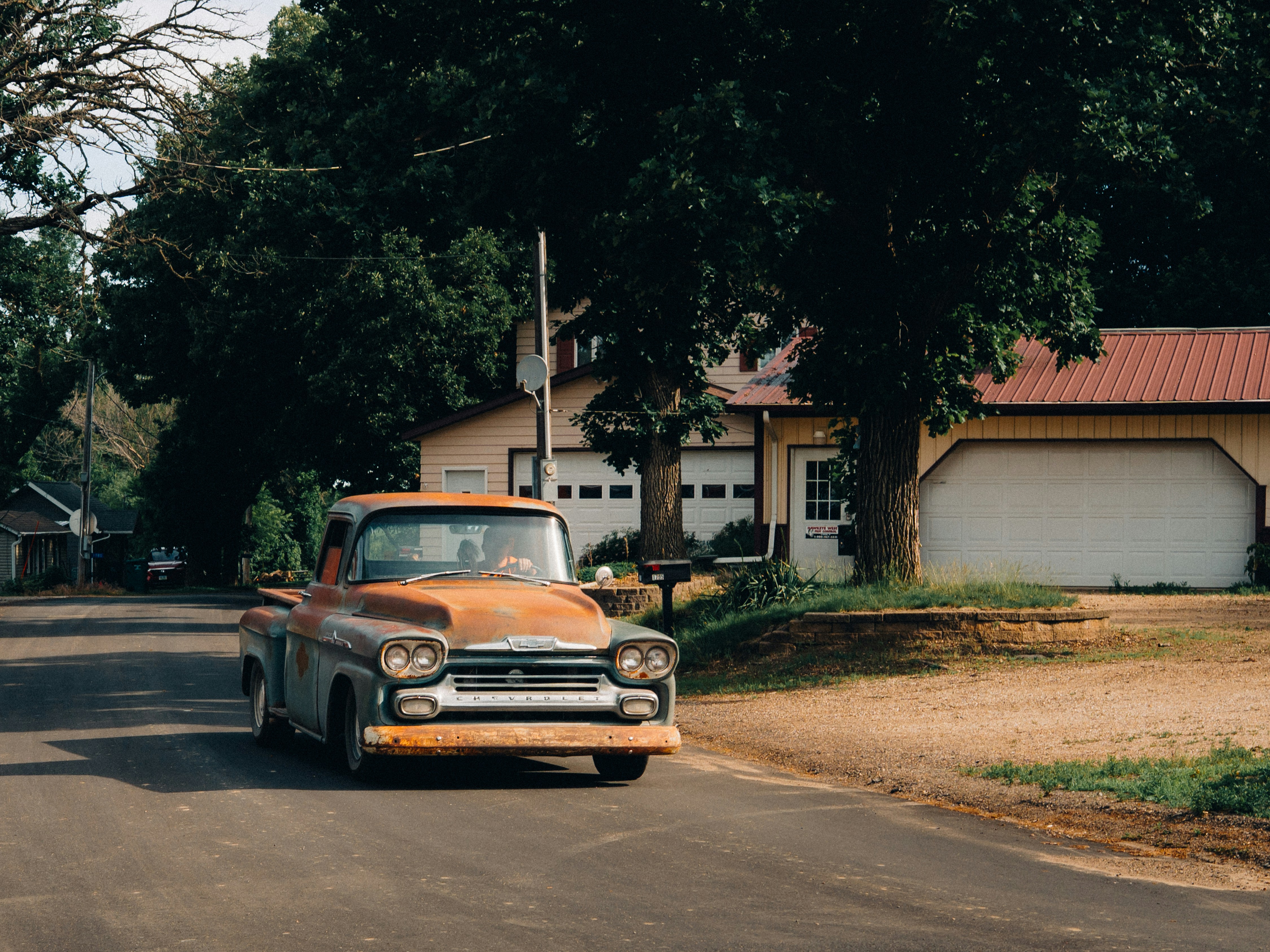 Orange classic pickup on a quiet suburban street