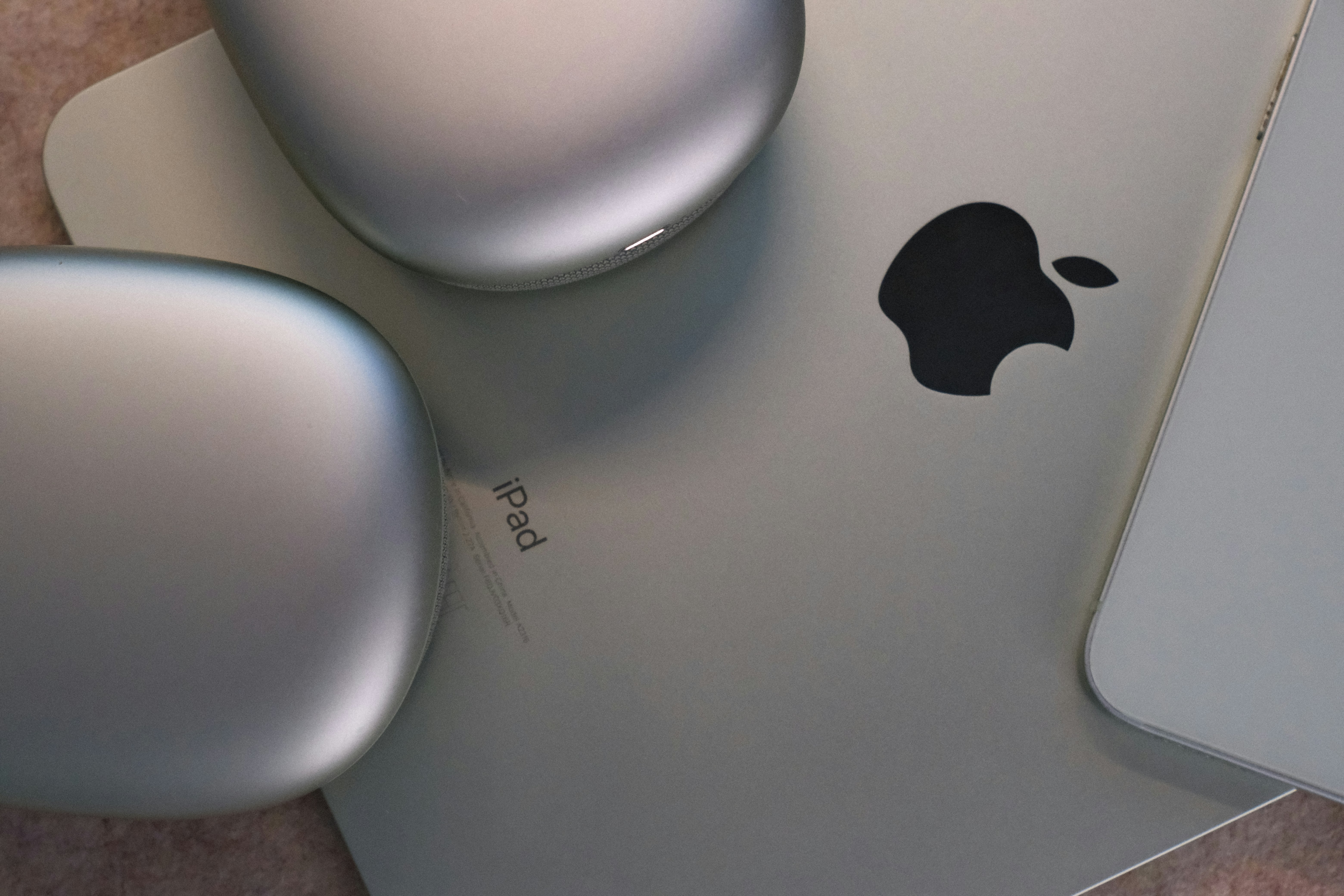 Apple iPad and silver airpods max headphones.