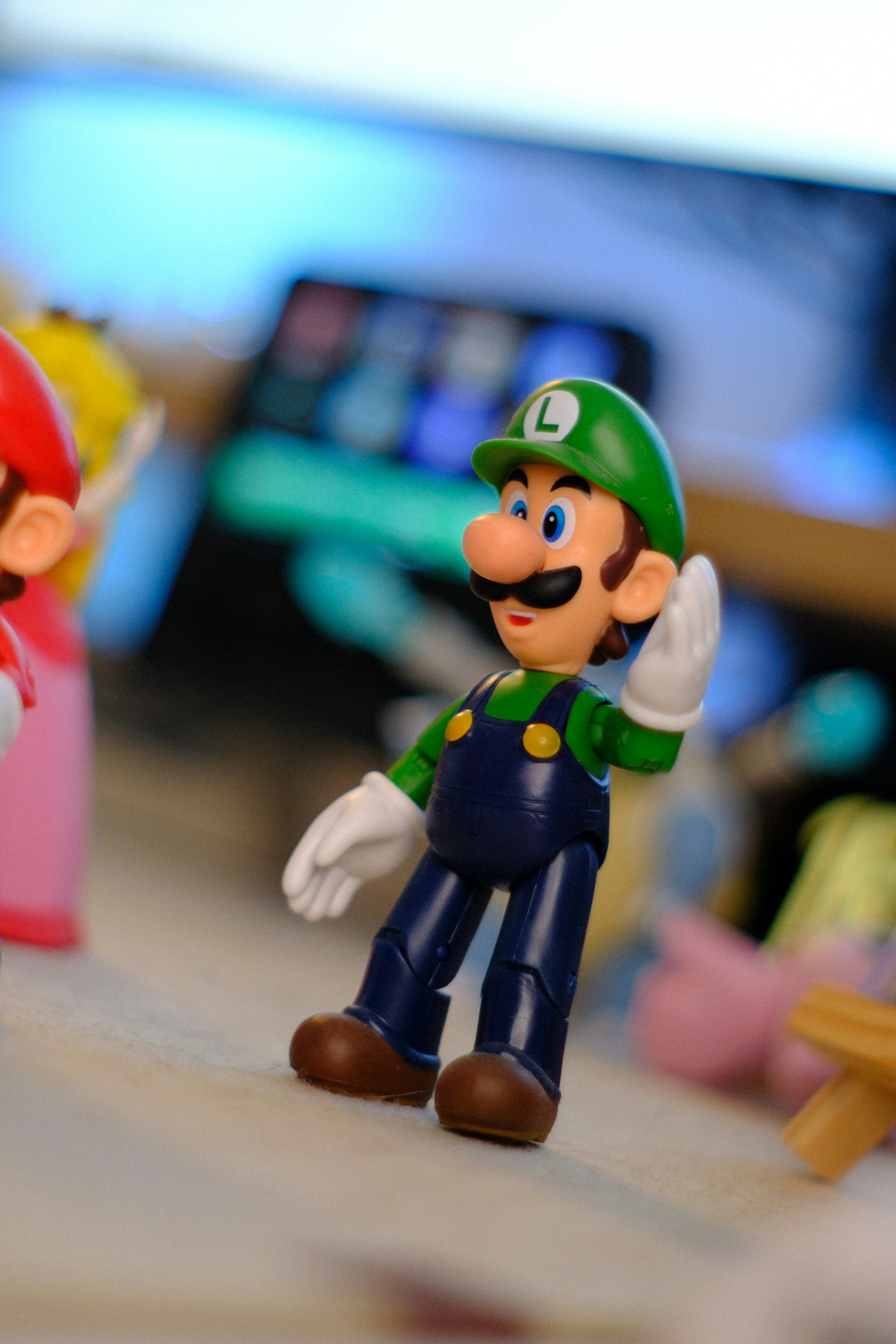 A luigi action figure standing with a blurry background.