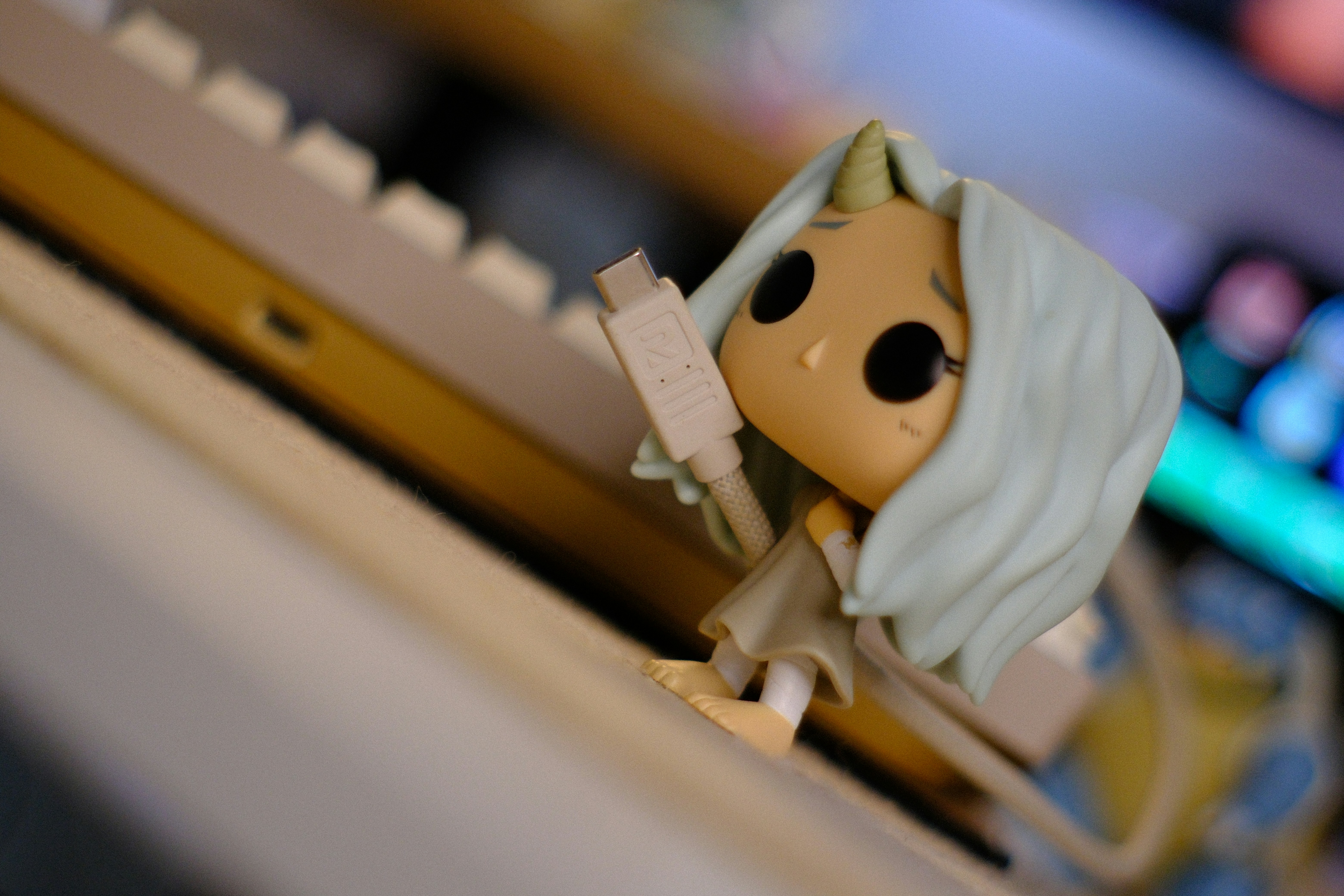 Tiny YouTuber in Miniature Gear: A Portrait of a Button-Nosed Figure at Tilted Desk