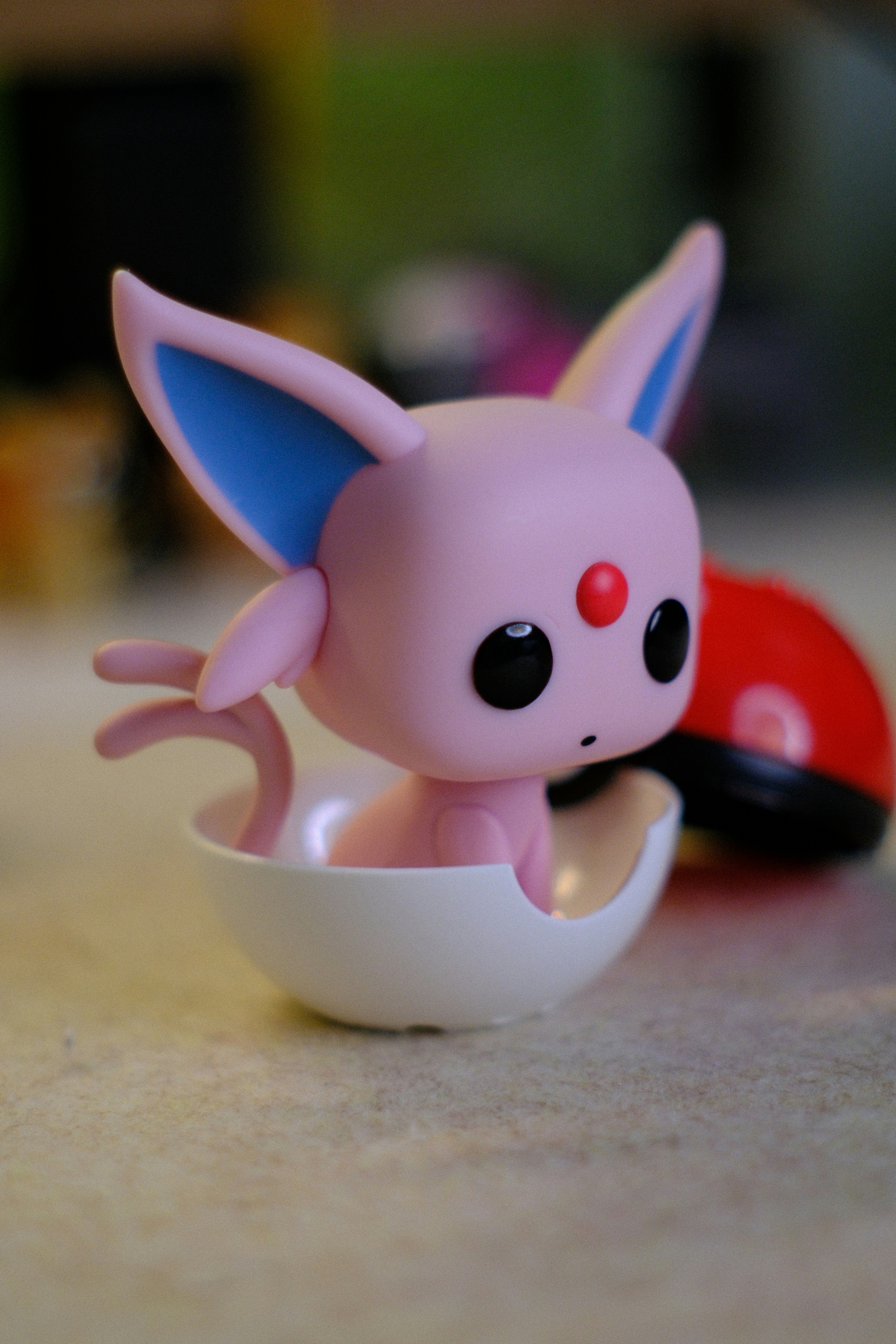 Pink creature hatching from a ceramic sheller, a playful toy in bloom