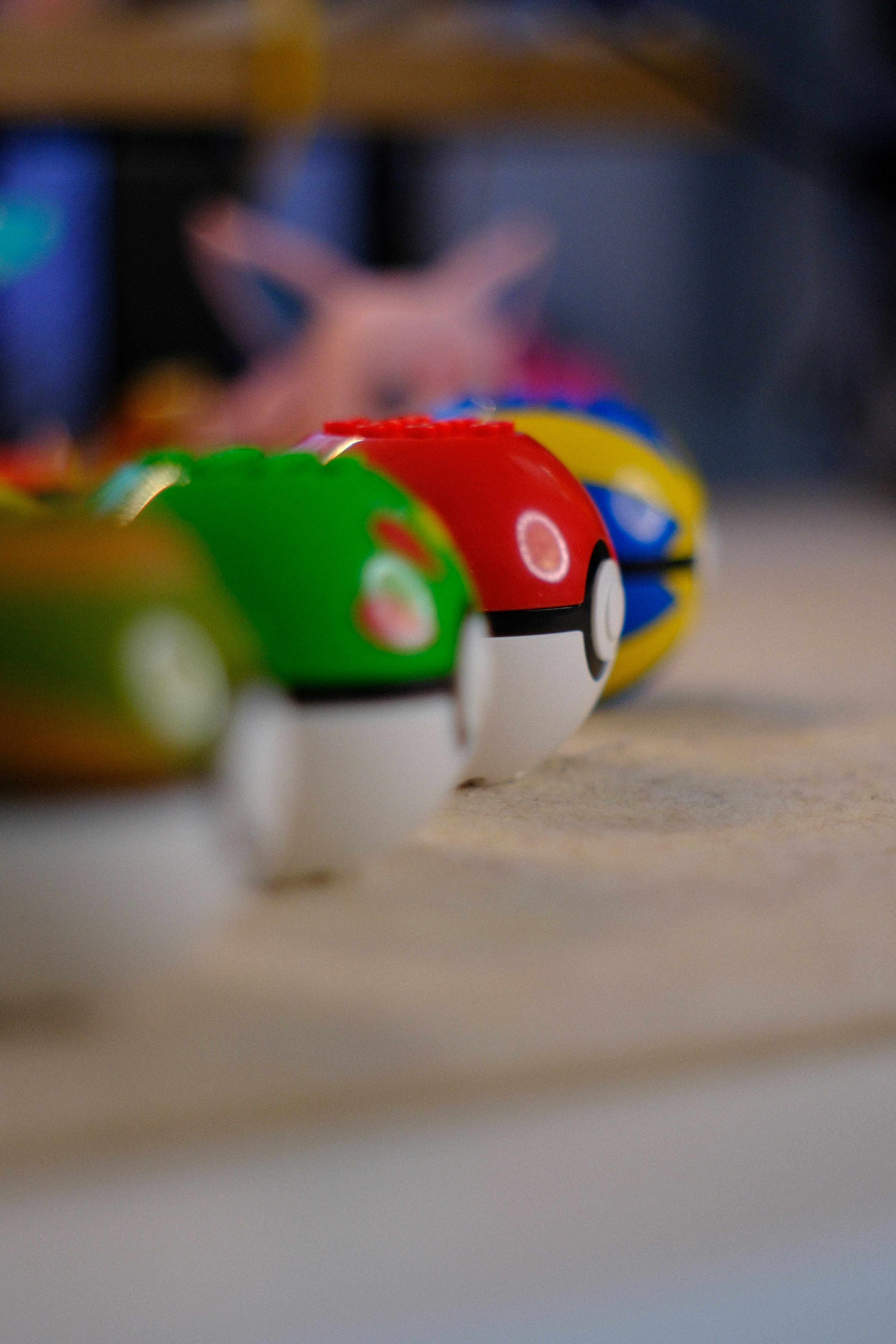 Colorful pokeball toys lined up on a surface.