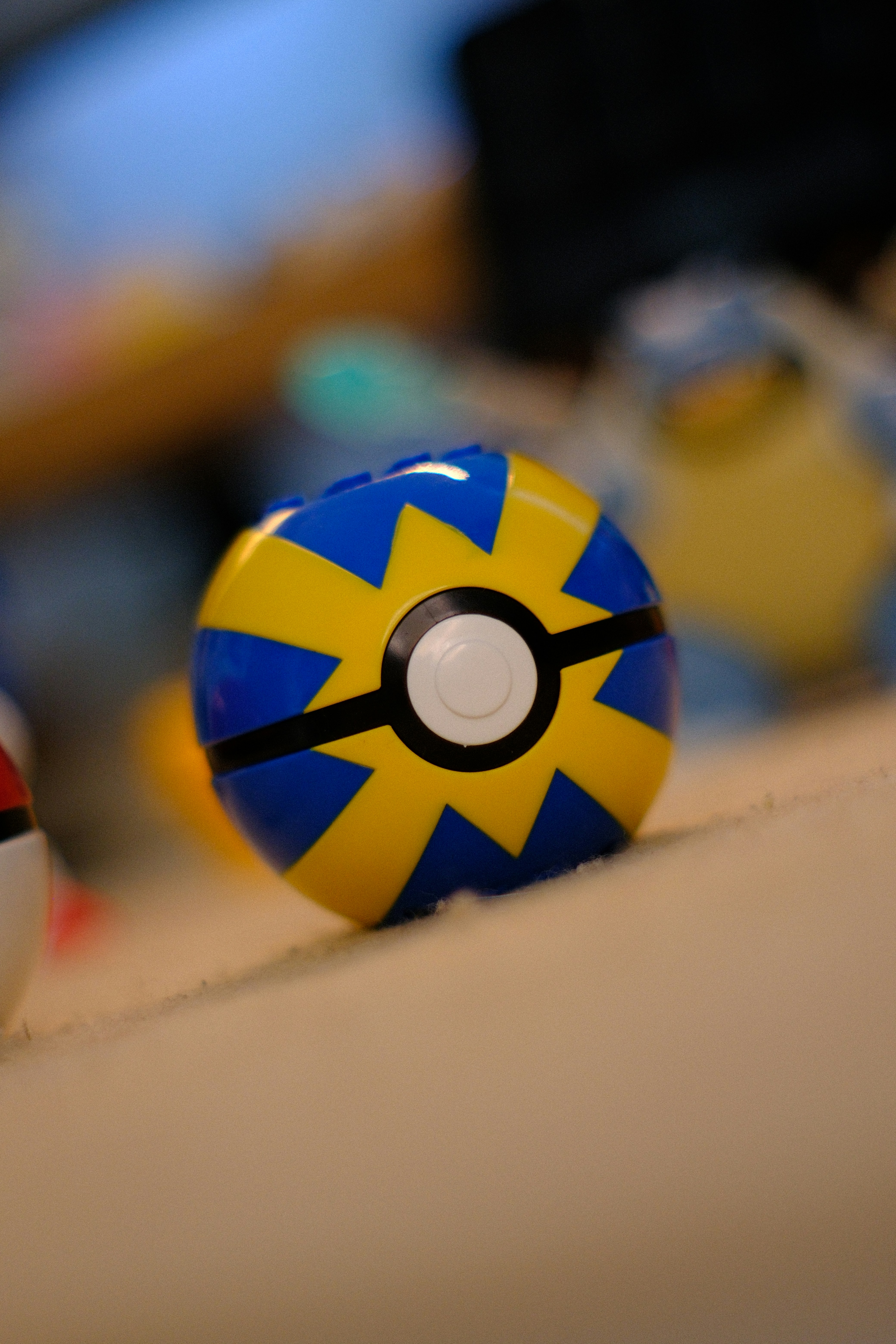 Colorful Orb: A Playful Poké Ball Among Soft Foreground Blur