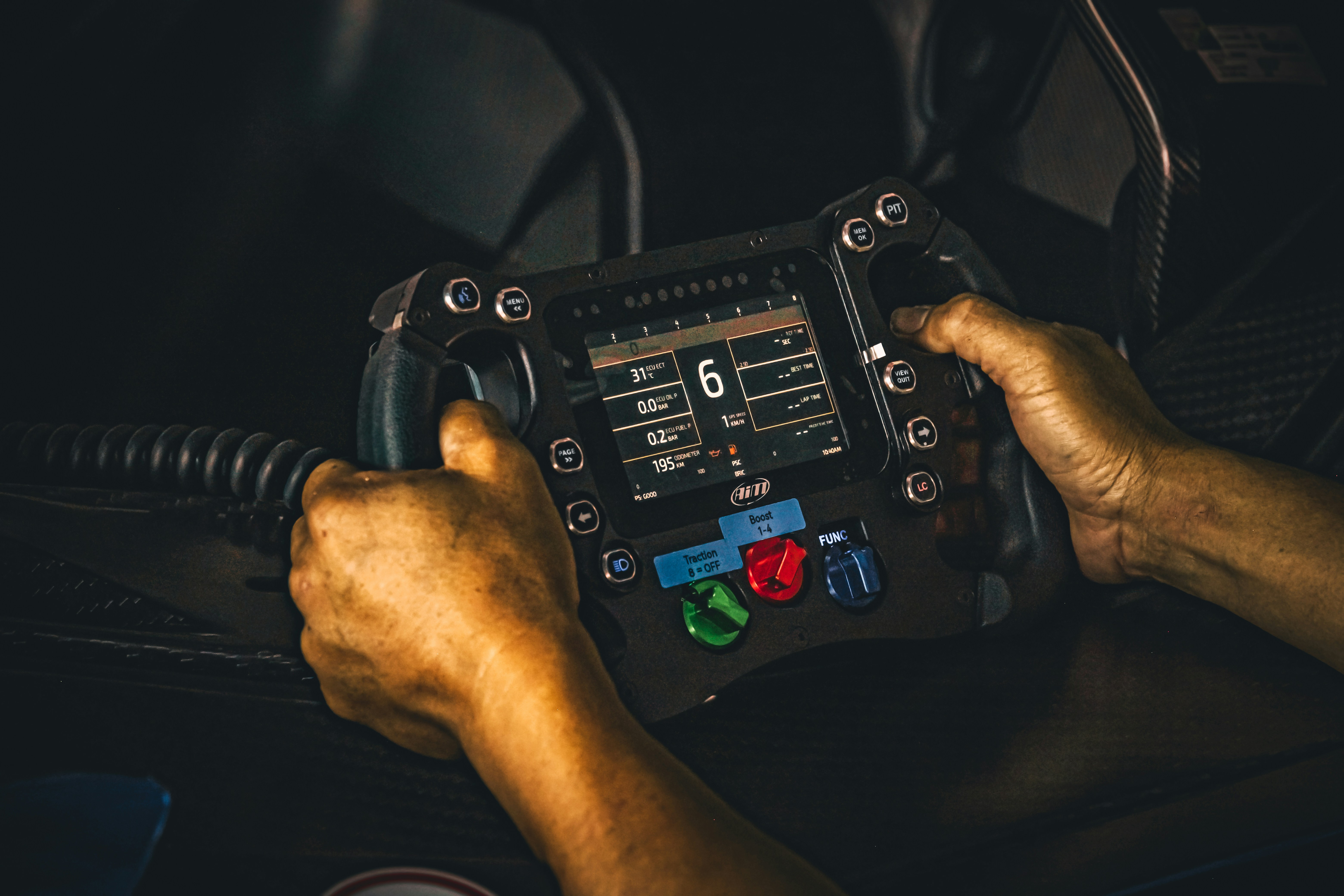 Driver Preparing for Race with Digital Motorsport Steering Wheel at Thailand Super Series A close-up view of a racing driver's hands gripping an advanced motorsport steering wheel equipped with a digital dashboard inside a race car cockpit during the Thailand Super Series at Chang International Circuit, Thailand. The image highlights modern racing technology, vehicle telemetry, and the intense focus required in professional motorsport competition. The intense world of motorsport from the driver's perspective—hands firmly on the wheel, eyes on the data, and every detail focused on performance.
