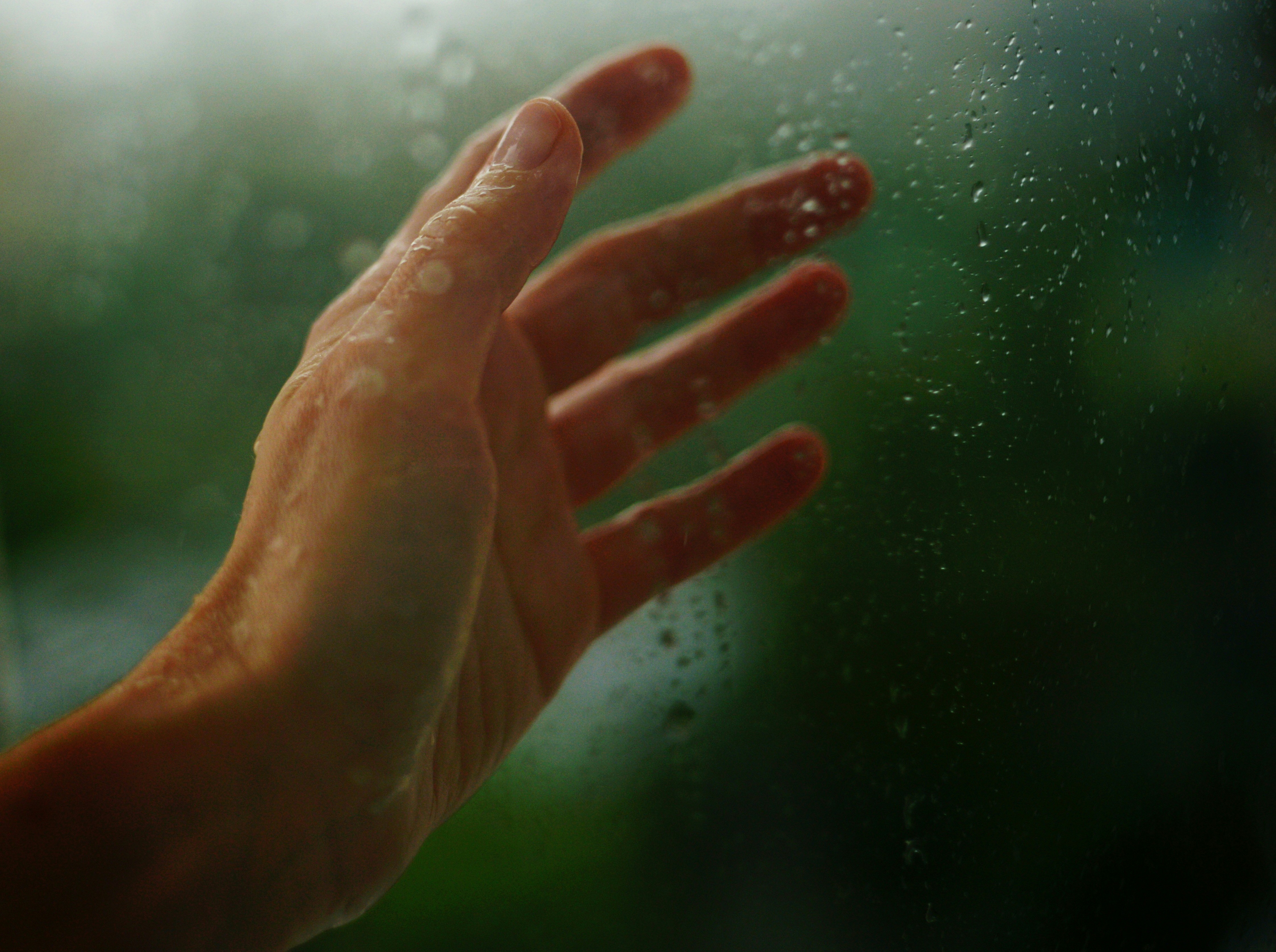 Touch Through the Glass: A Hung Hand Reaches for Rain on Window