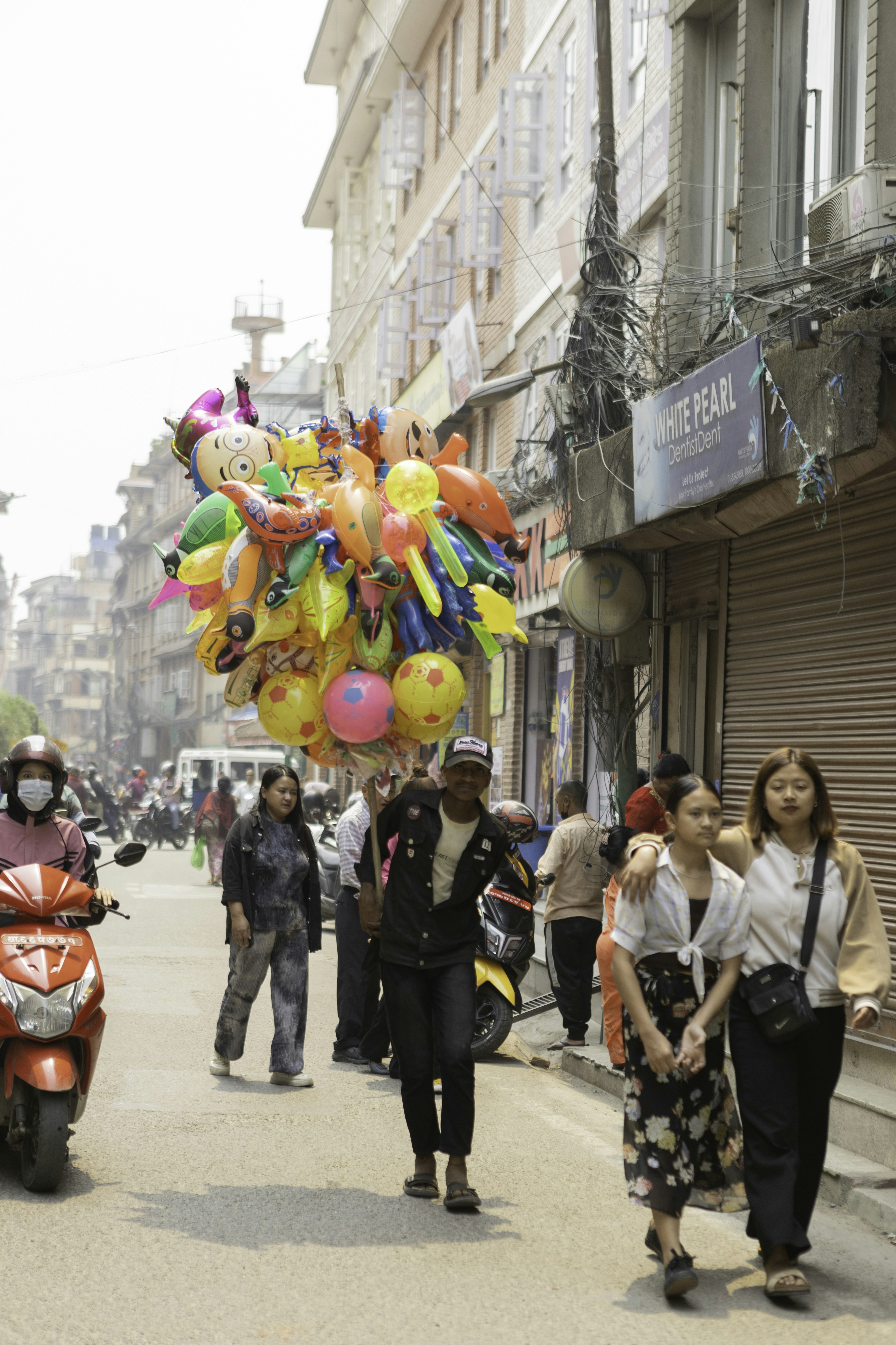 Street Vendor with Balloon Bouquet Traversing a Busy Bazaar