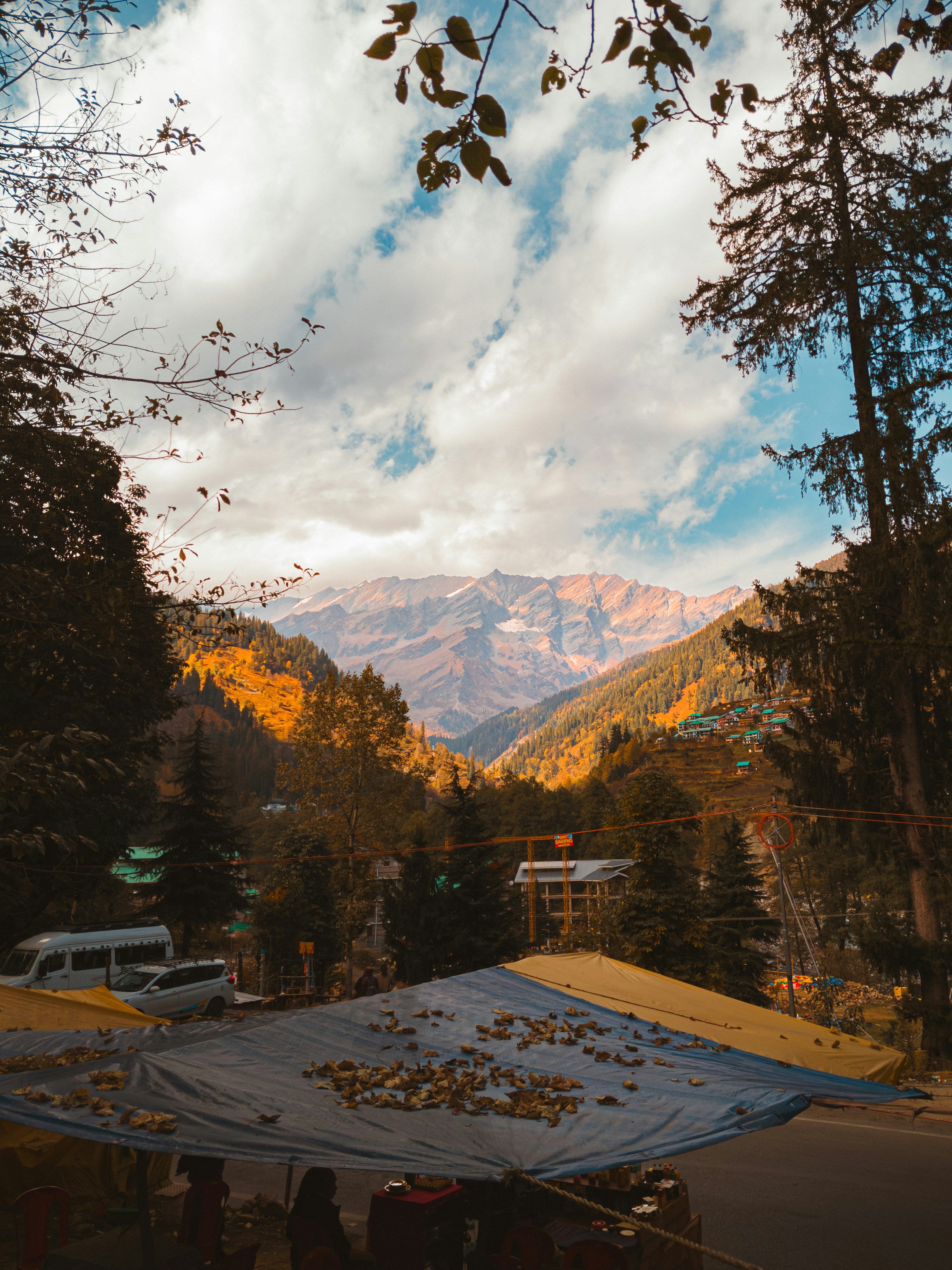 Autumn mountain valley with a market stall under cloudy sky.