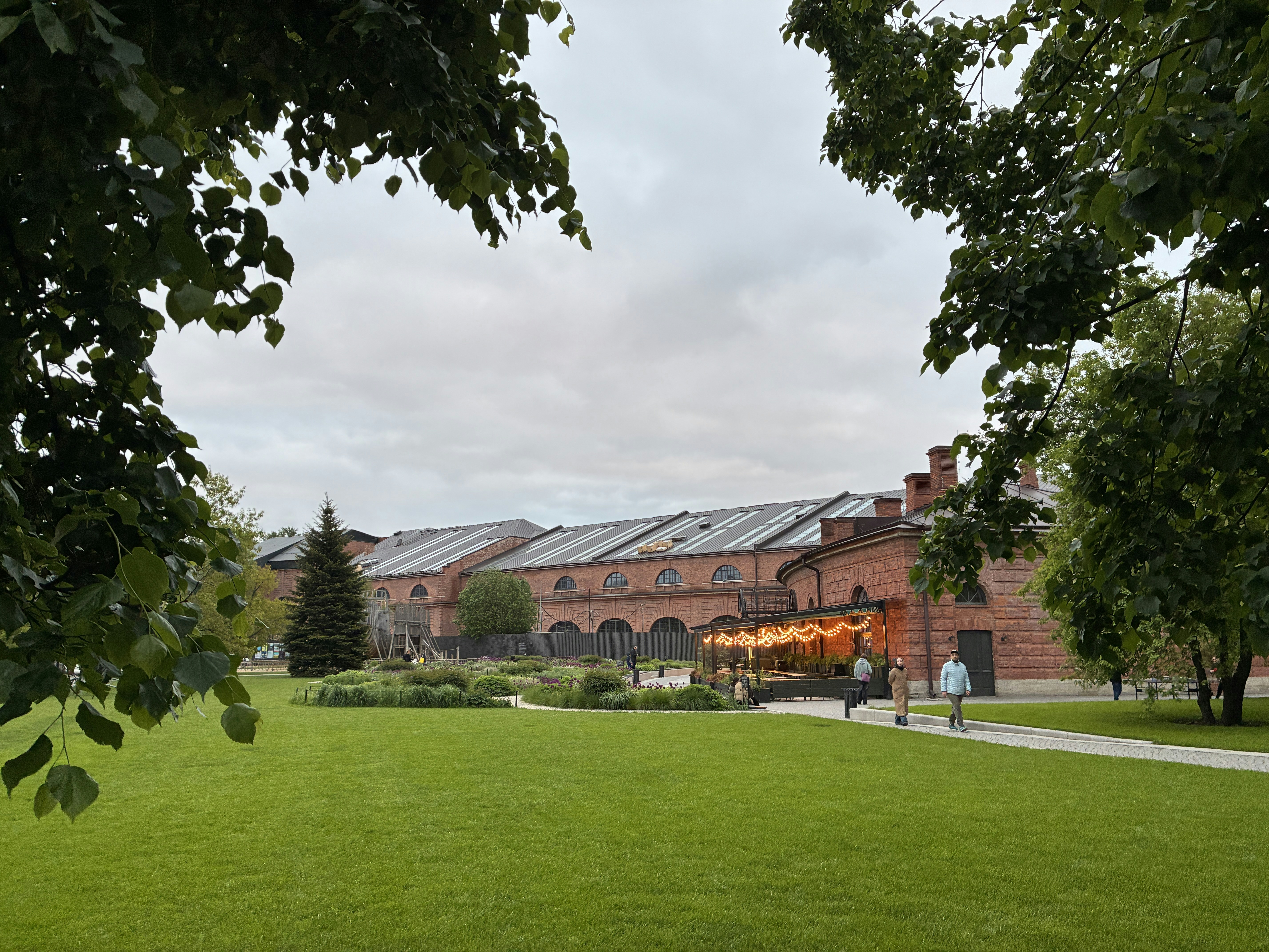Brick Courtyard with Glass-roofed Greenhouse set in a sunlit lawn