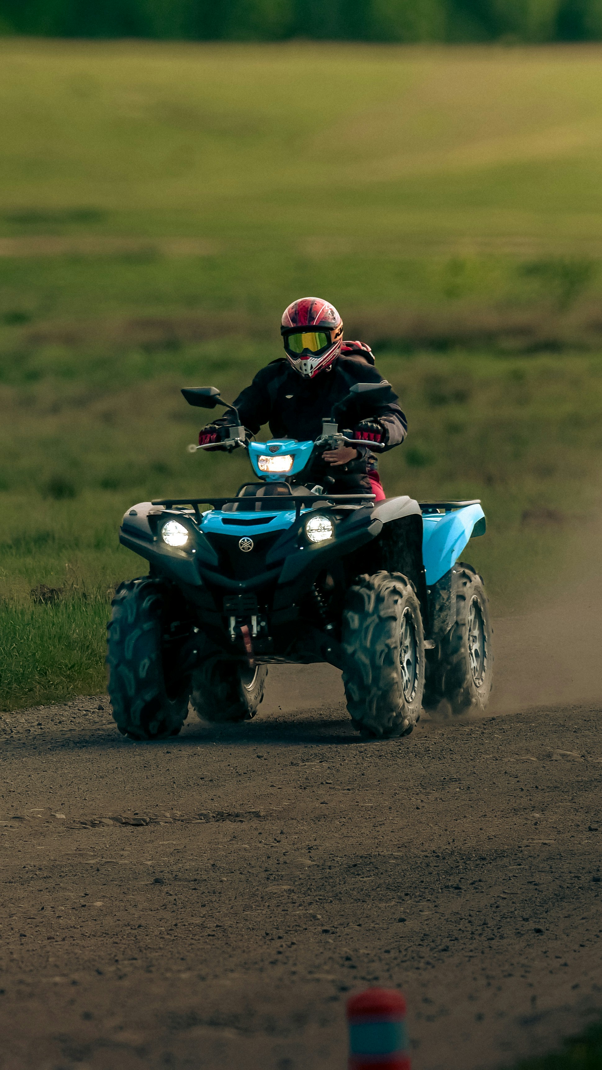 Blue quad bike charge across a dusty track