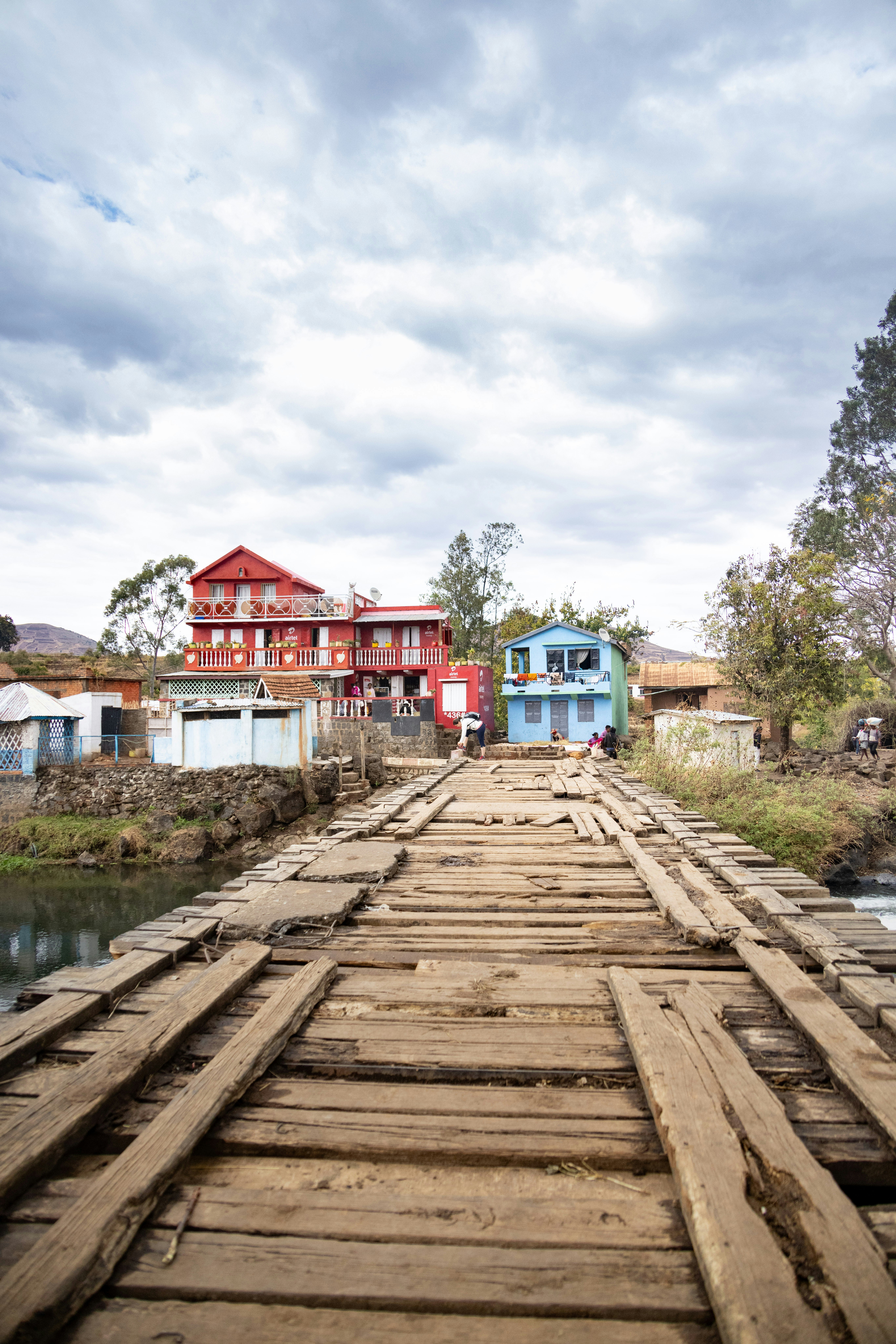 Colorful riverside cottages framed by a weathered wooden causeway