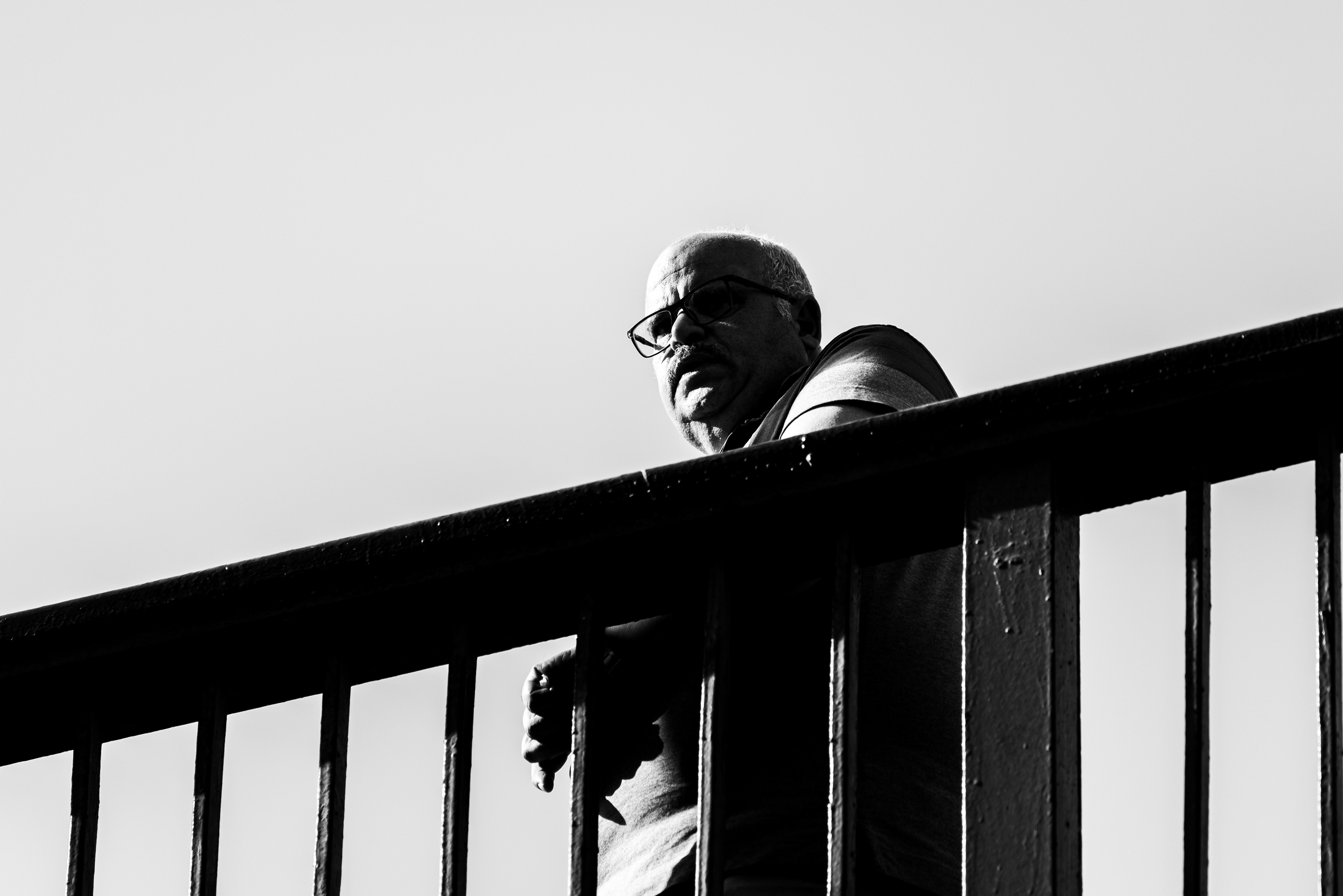 Over the Rail: A Quiet Portrait at Ground Level