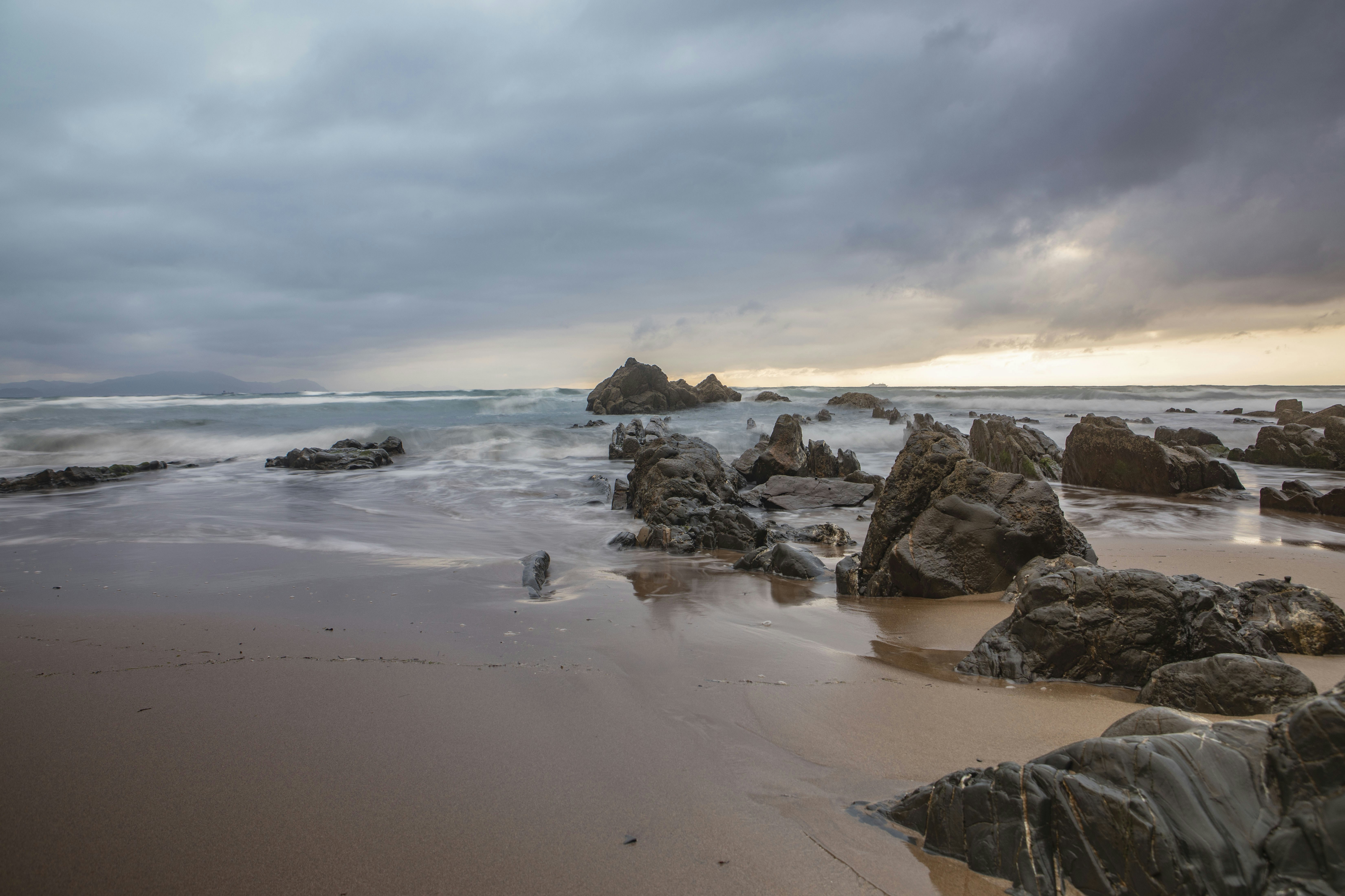 Rugged Shoreline at Dusk: Jagged Rocks and Soft Waves