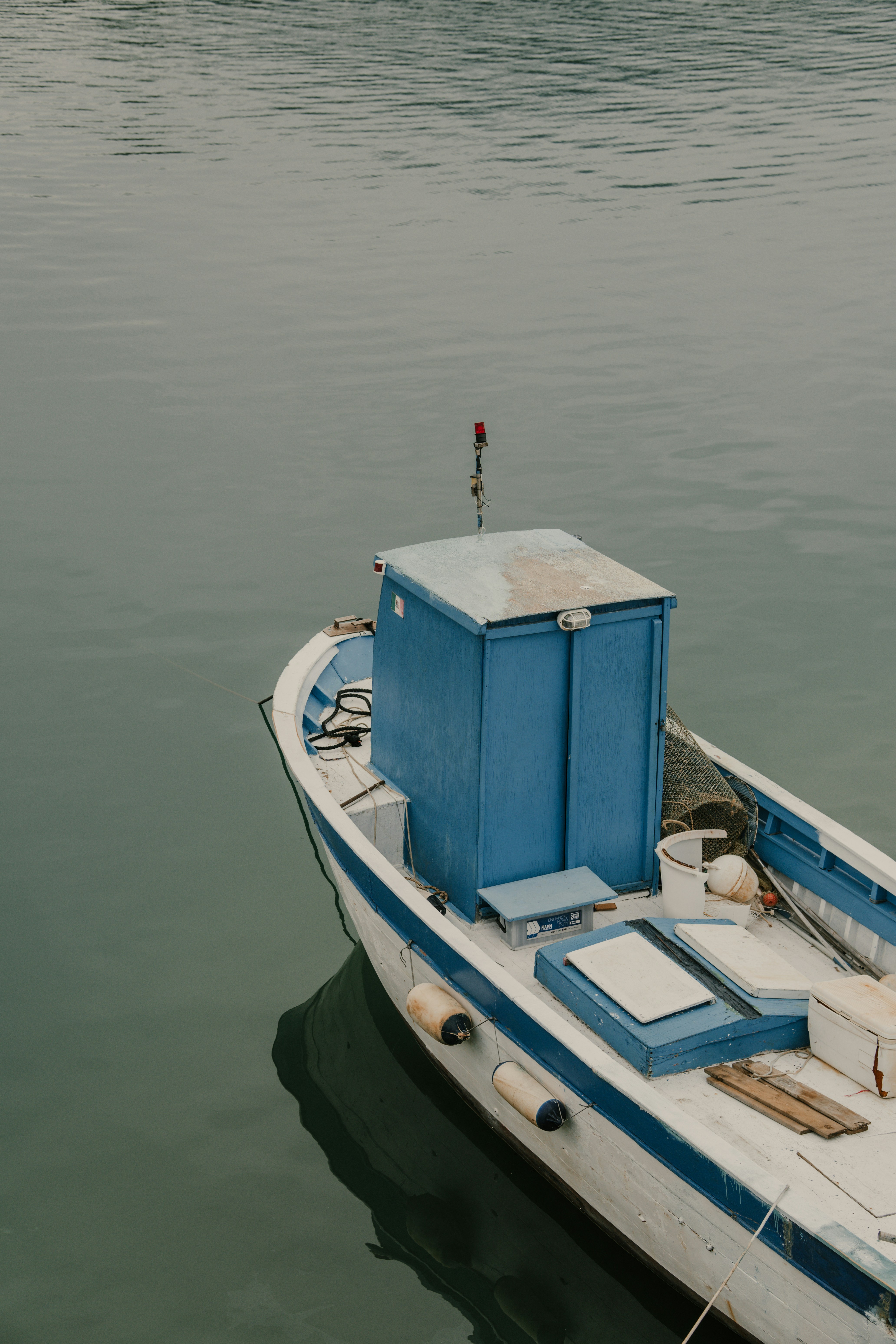Blue Boat at the Calm Harbor: A Quiet Maritime Moment