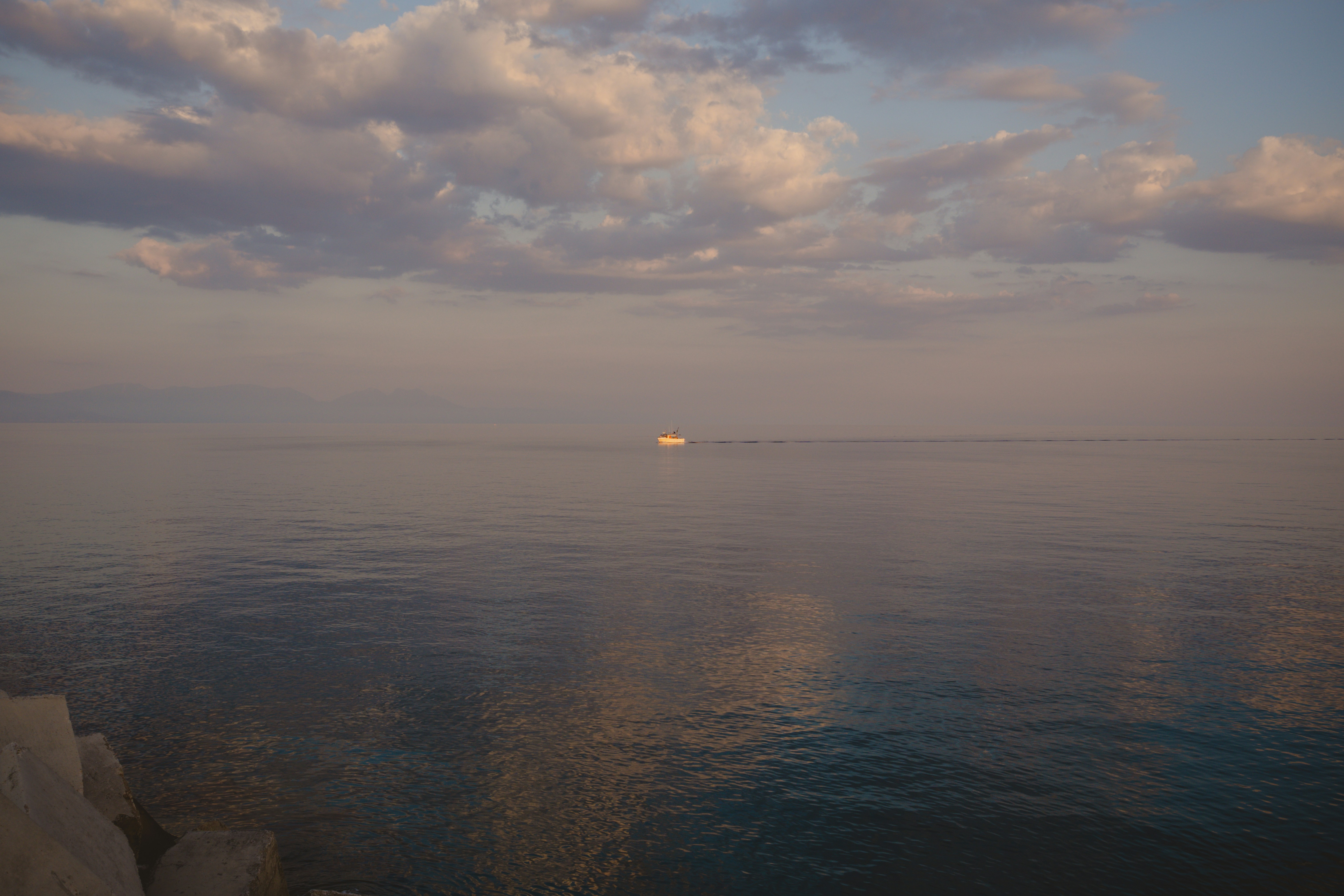 Distant Vessel at Dusk: A Quiet Sea Lapped by Light