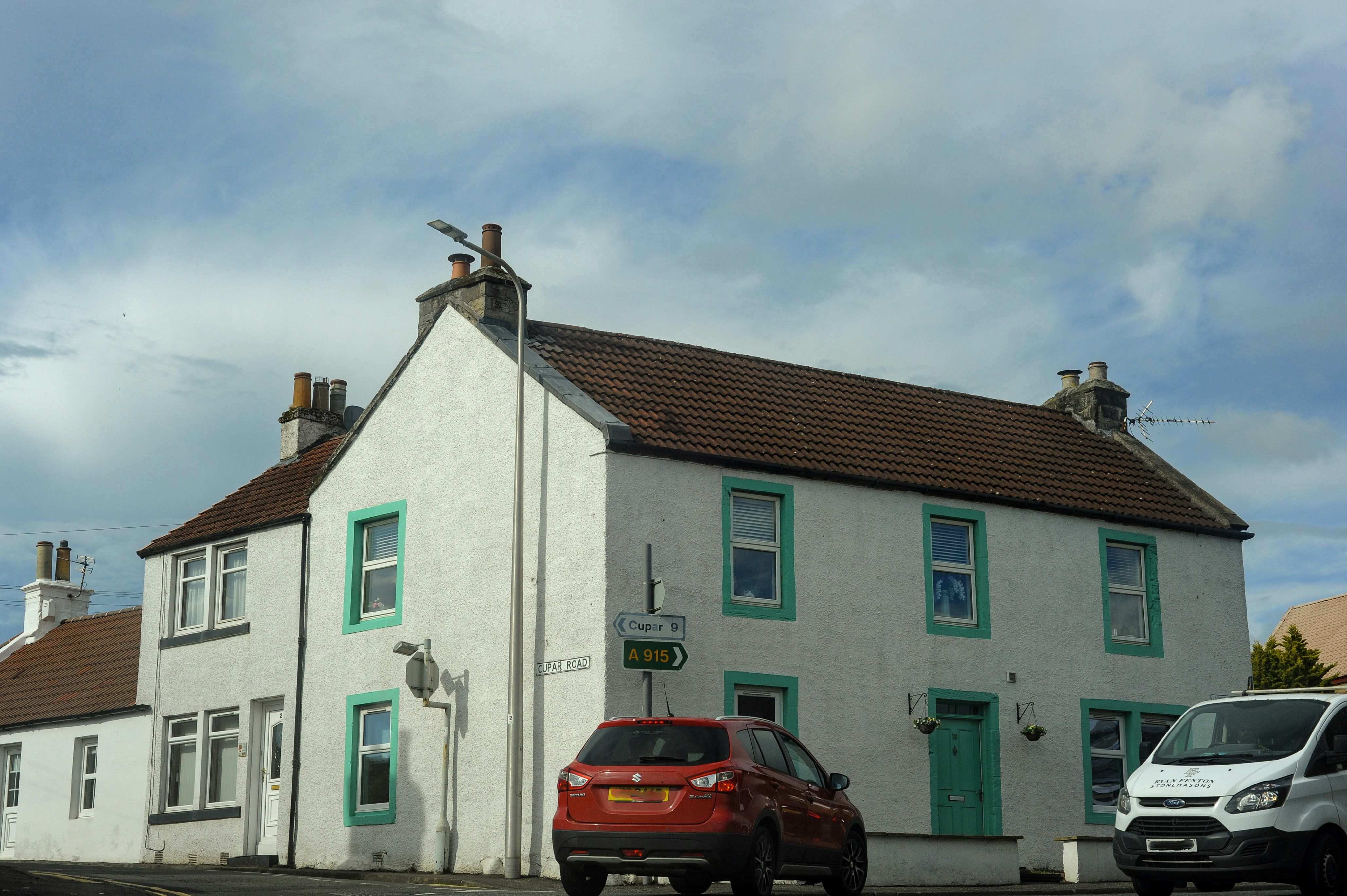 Cottage Row with Bright Turquoise Accents and a Red Car
