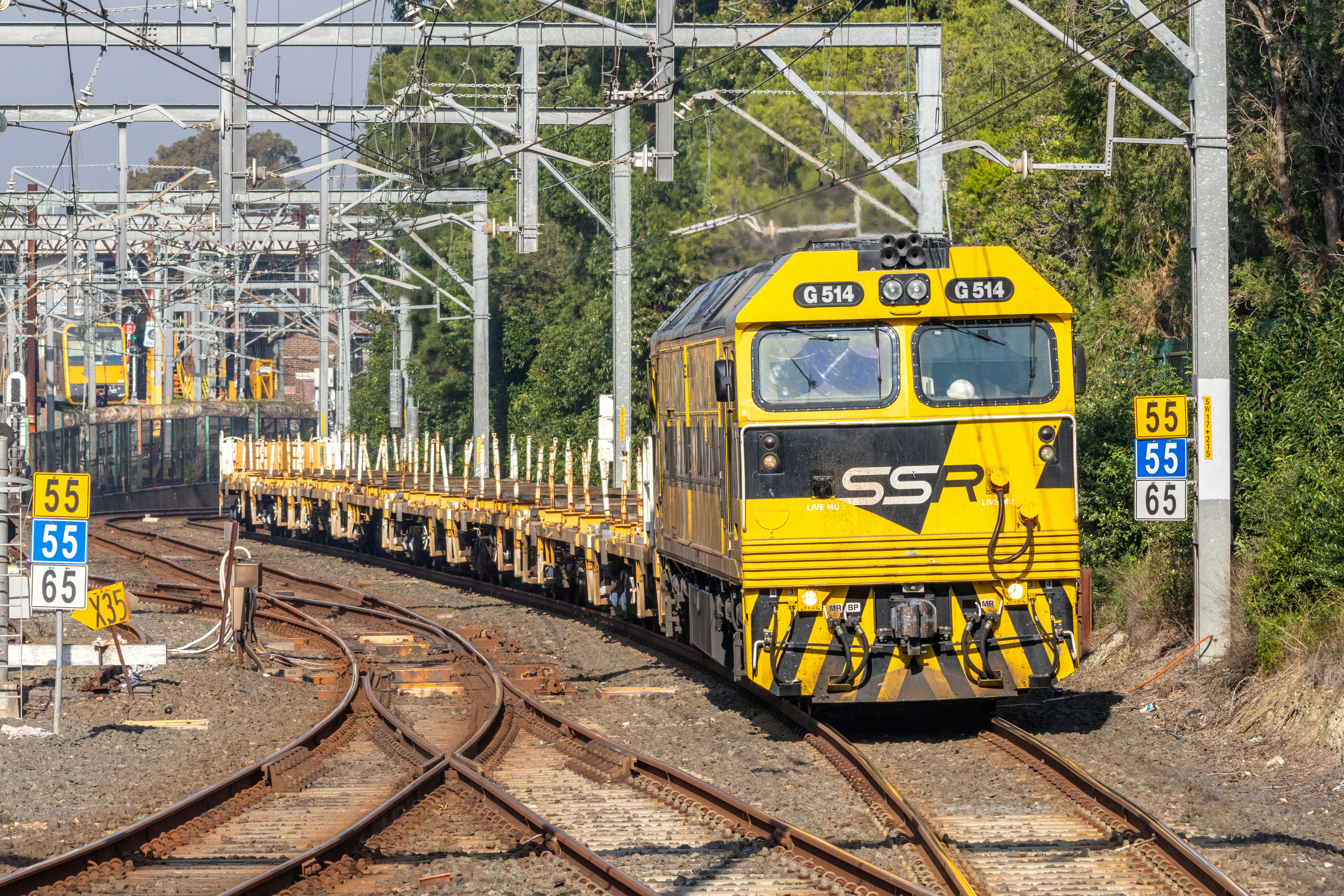 Yellow Freight Engine on Curving Tracks in a Jumbled Rail Yard