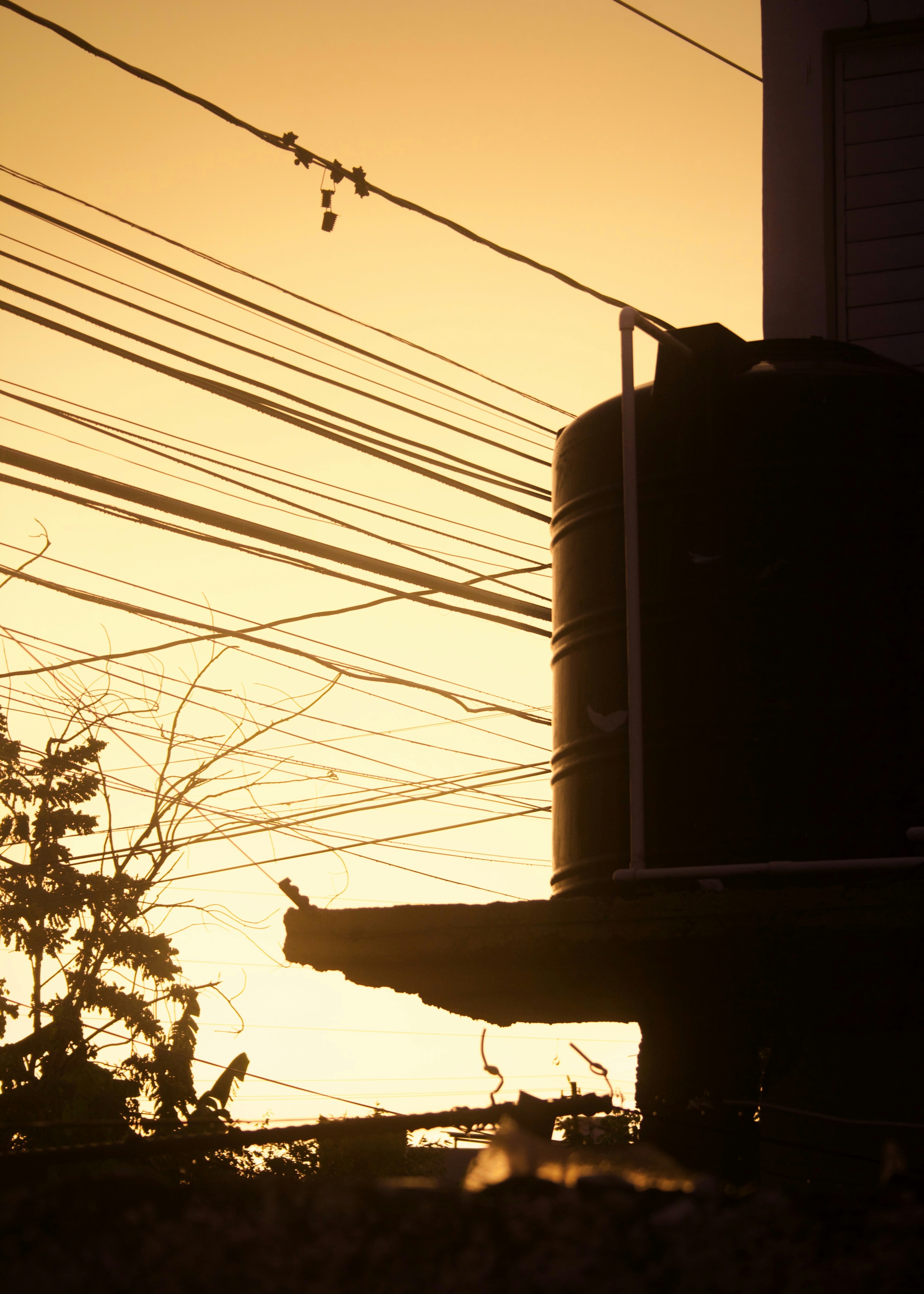 Sunset Silhouette over a Rooftop Water Tank