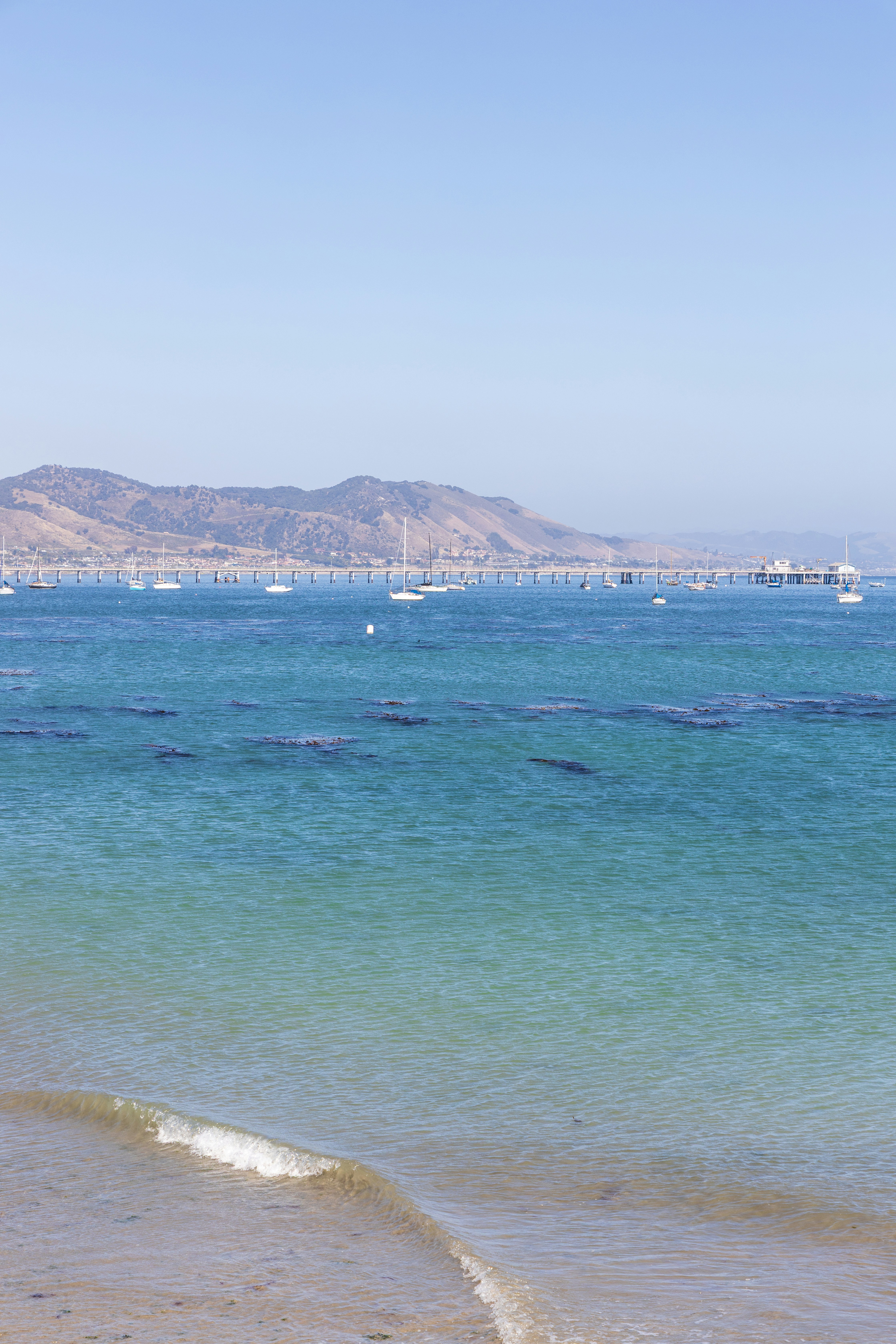 Azure Seascape with a Distant Pier and Gentle Shoreline