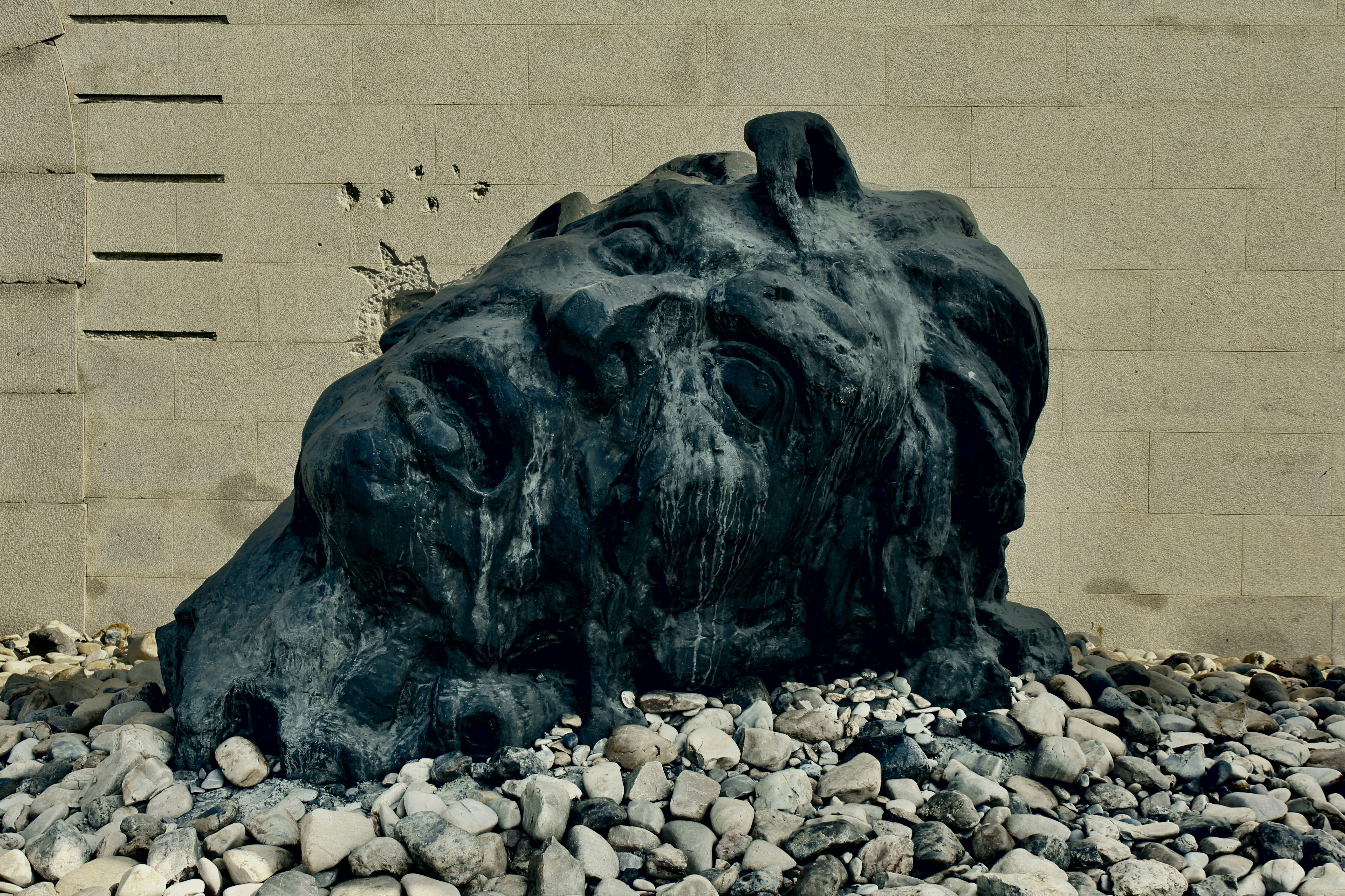 Collapsed Titan: A Weathered Bust Half-immersed in Pebbles
